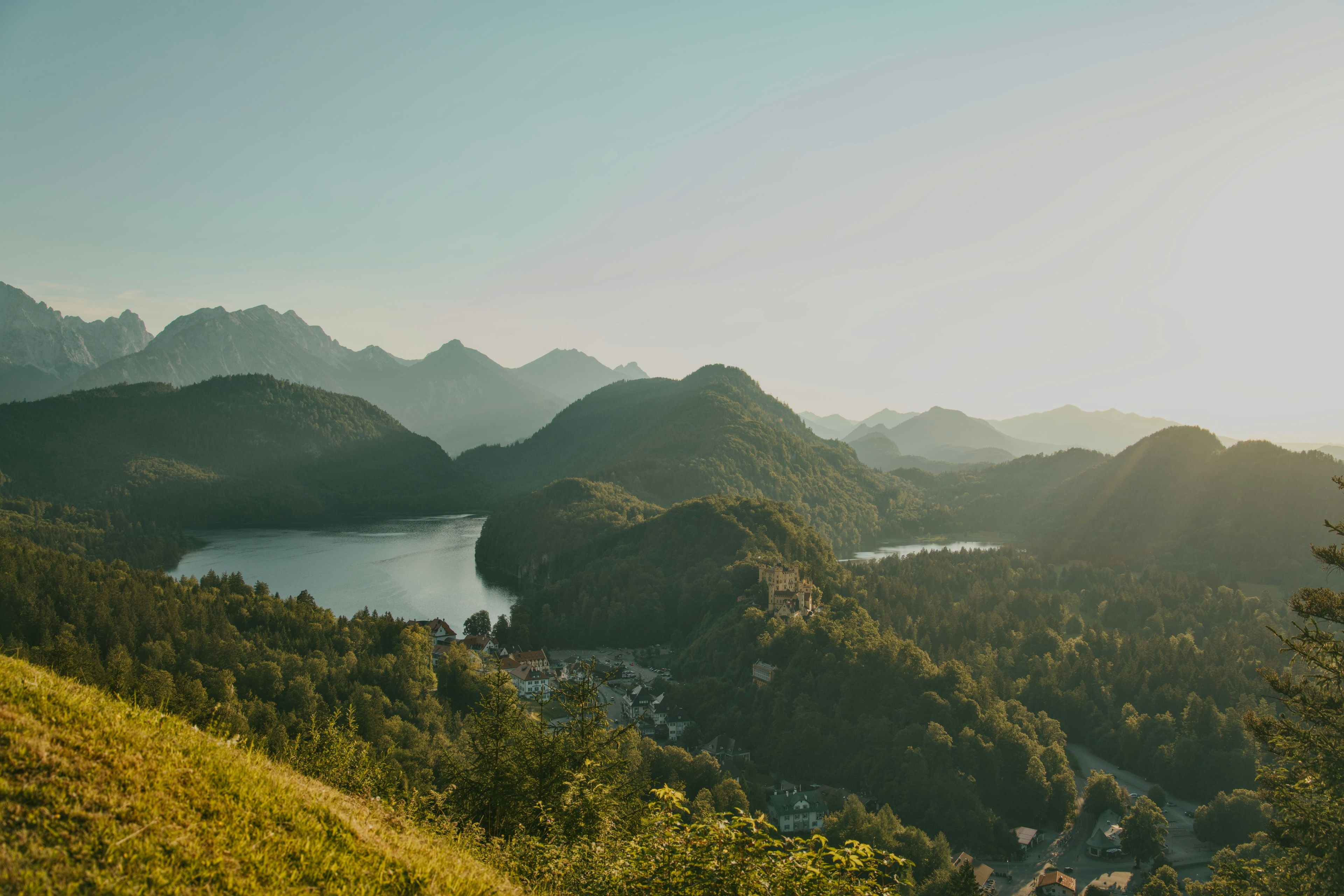 Sunlit Valleys and Misty Peaks Over a Quiet Lake