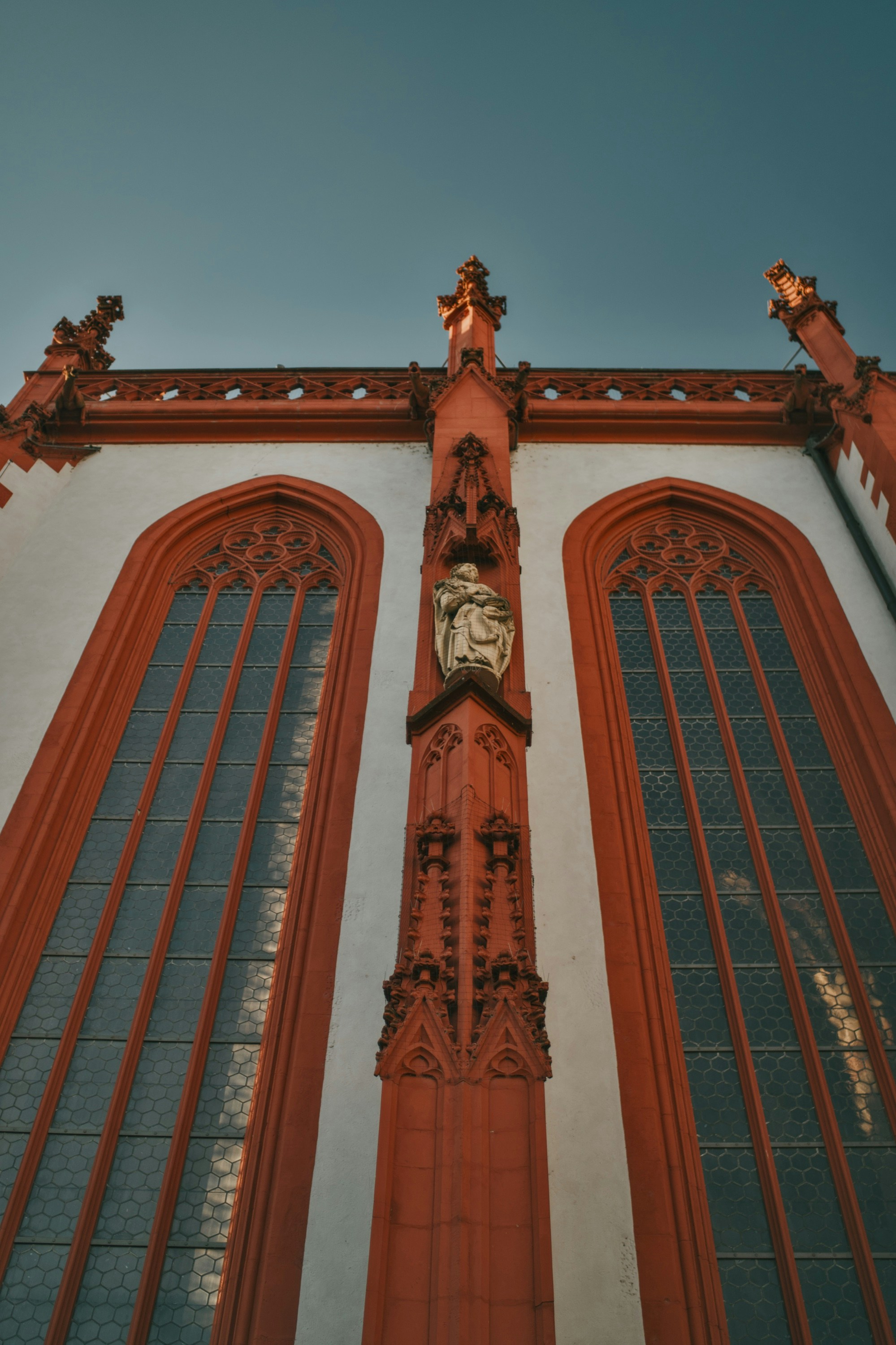 Red Gothic Arches: A Central Niche on a Sacred Facade