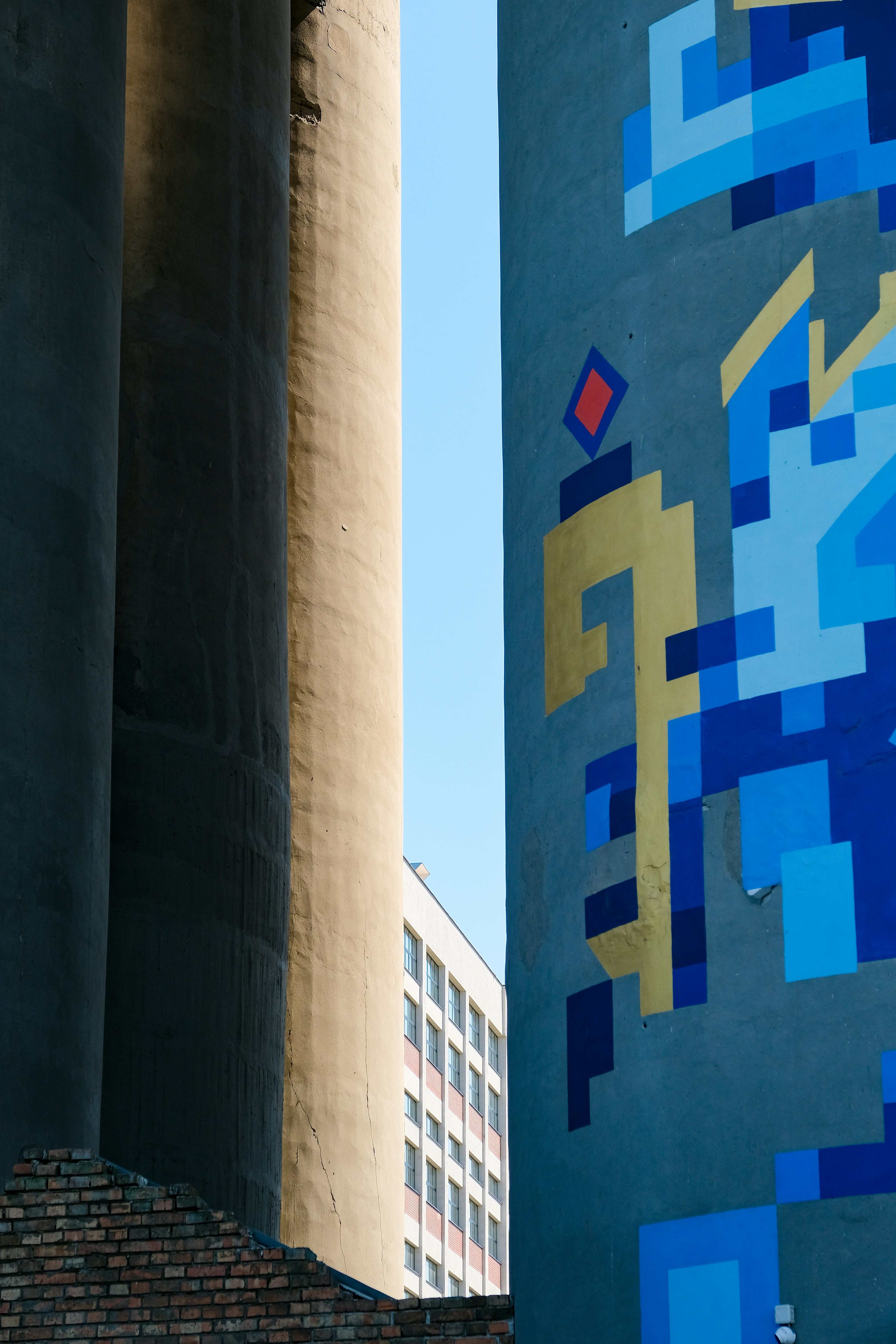 Colorful geometric mural on an industrial building.