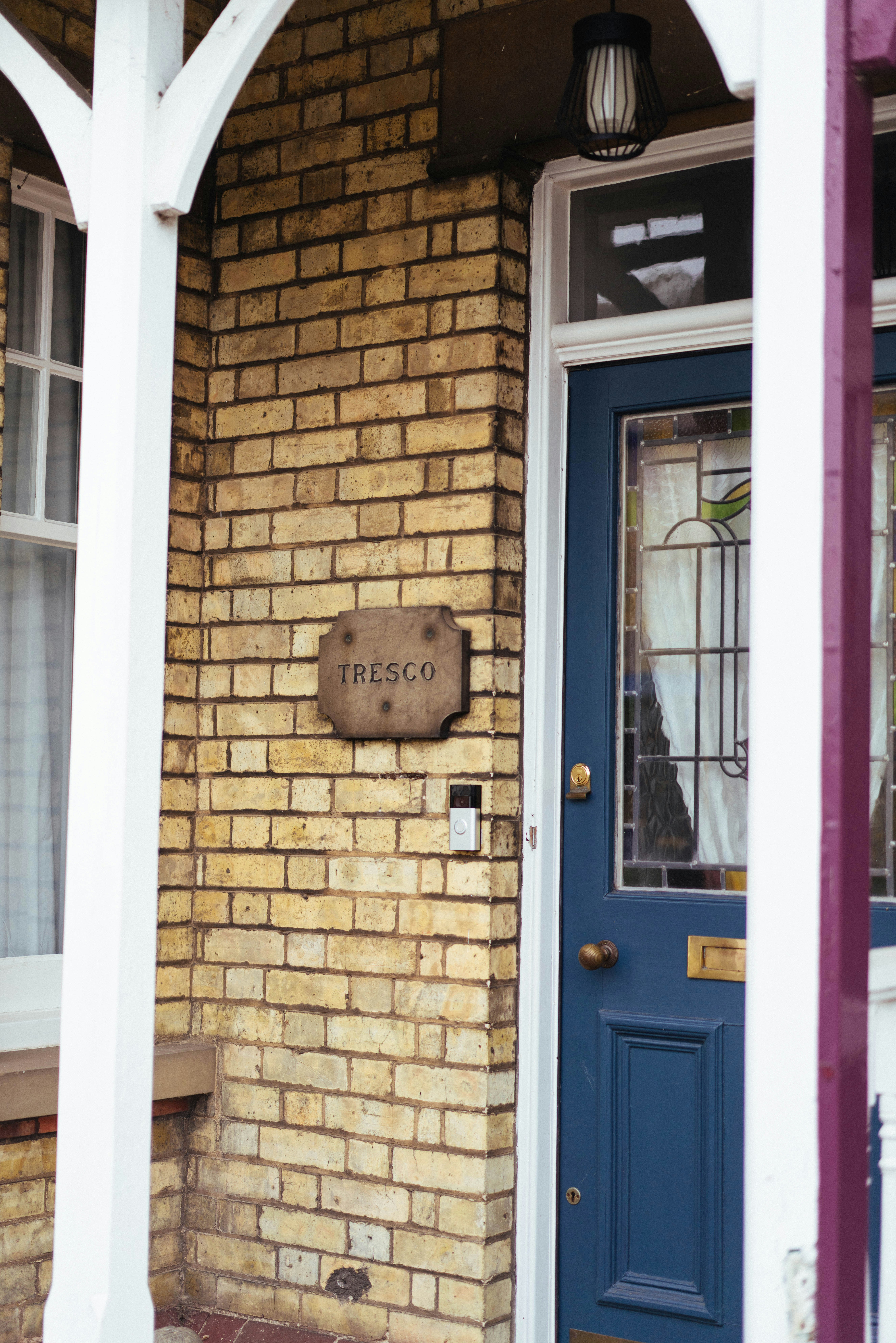 Blue Doorway on a Brick Terrace with Vintage Plaque