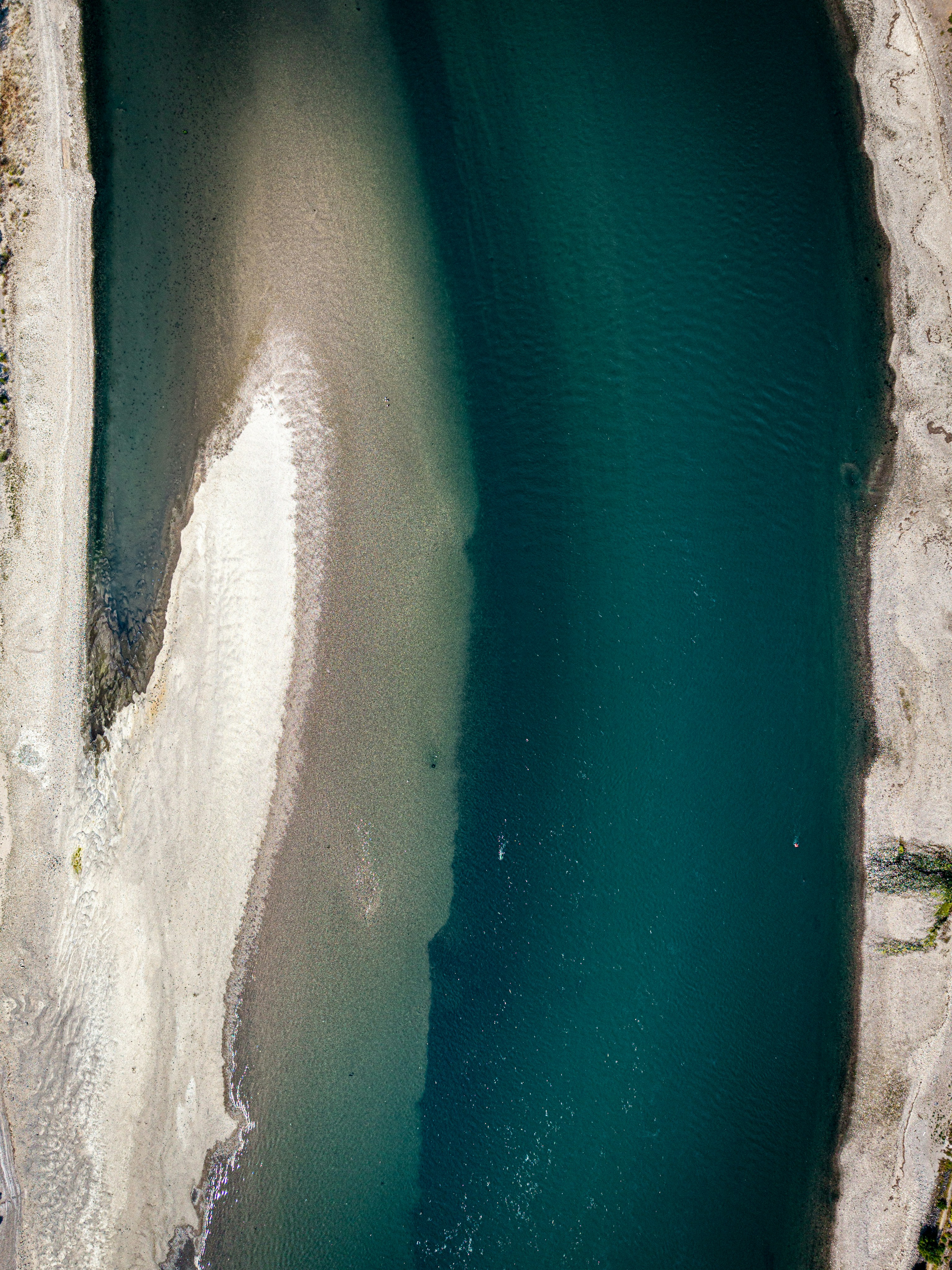 Aerial Ribbon: Turquoise Conduit Carved Between Stone Cliffs
