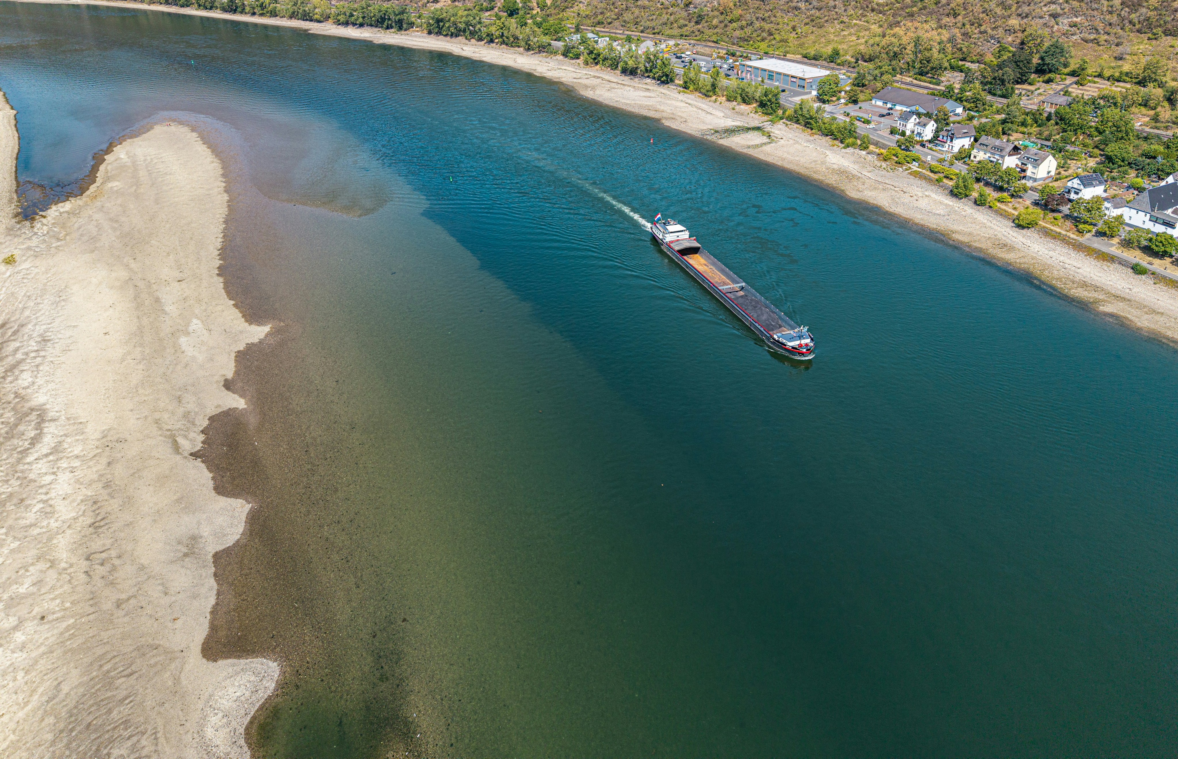 Aerial Calm: Barge Traverses a Quiet Coastal Channel