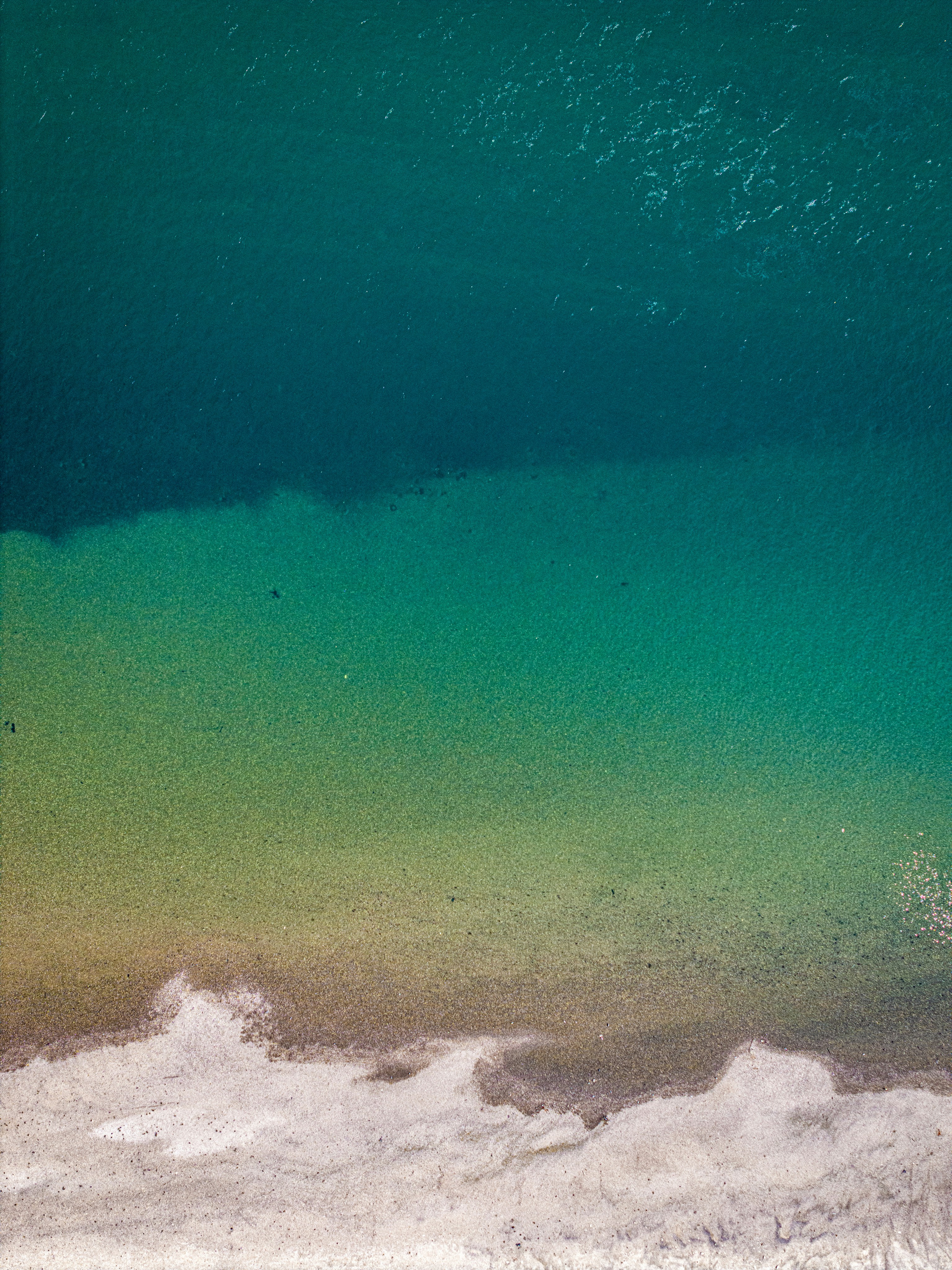 Coastal Gradient: Sea, Shore, and Turquoise Lagoon from Above