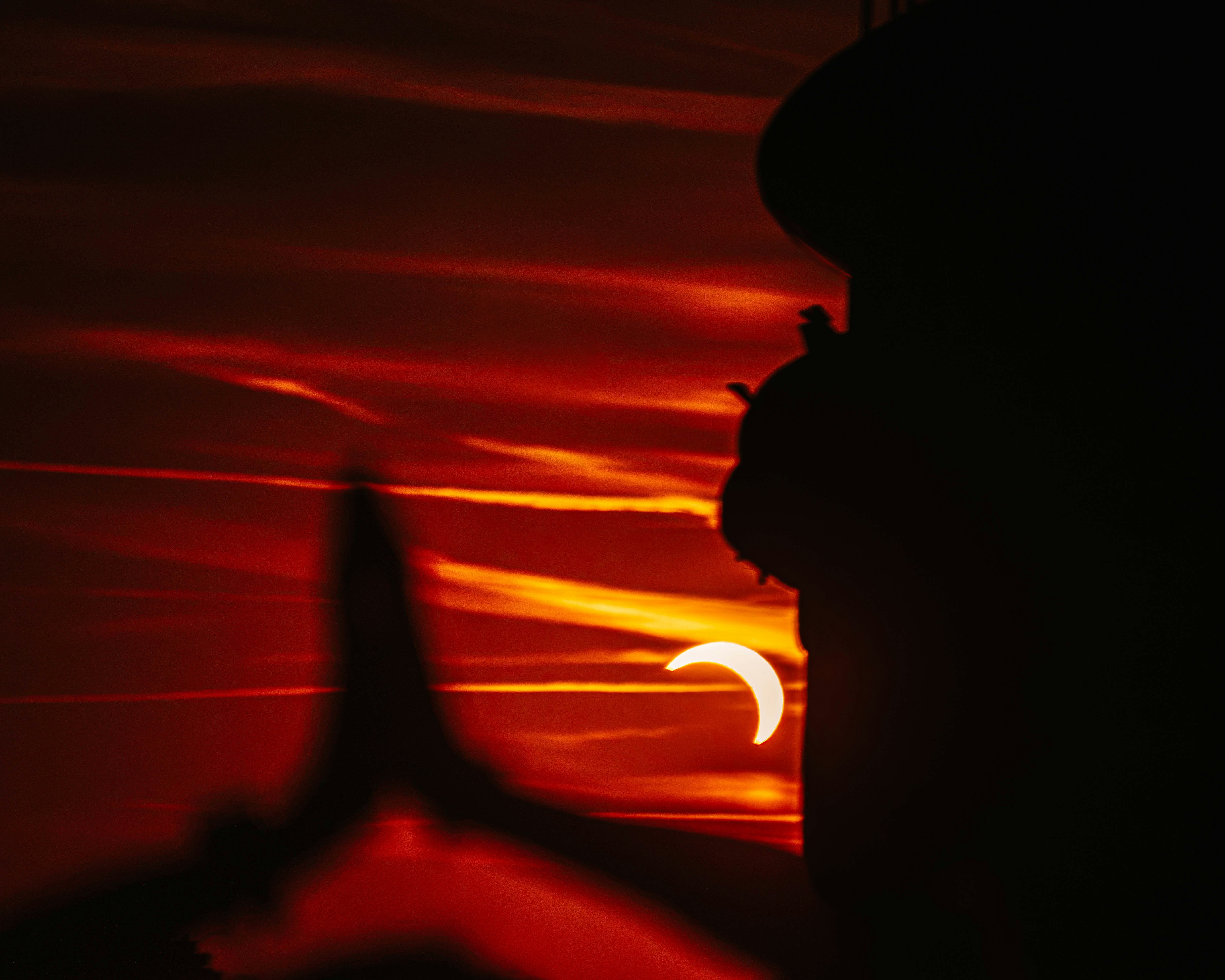 Silhouette at Sunset: Crescent Moon in a Fiery Sky