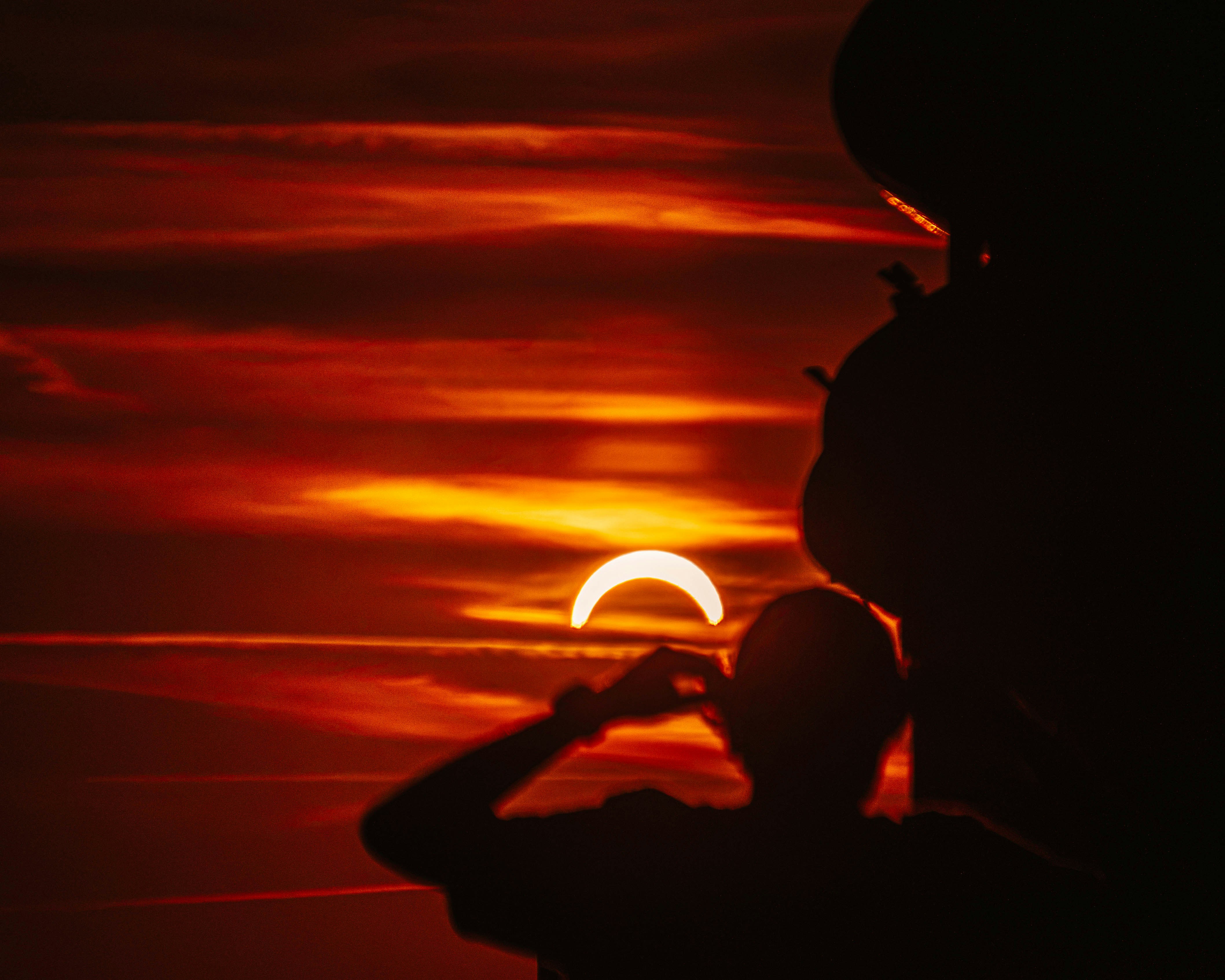 Solar Crescents: A Sunset Solar Eclipse Framed by Silhouettes