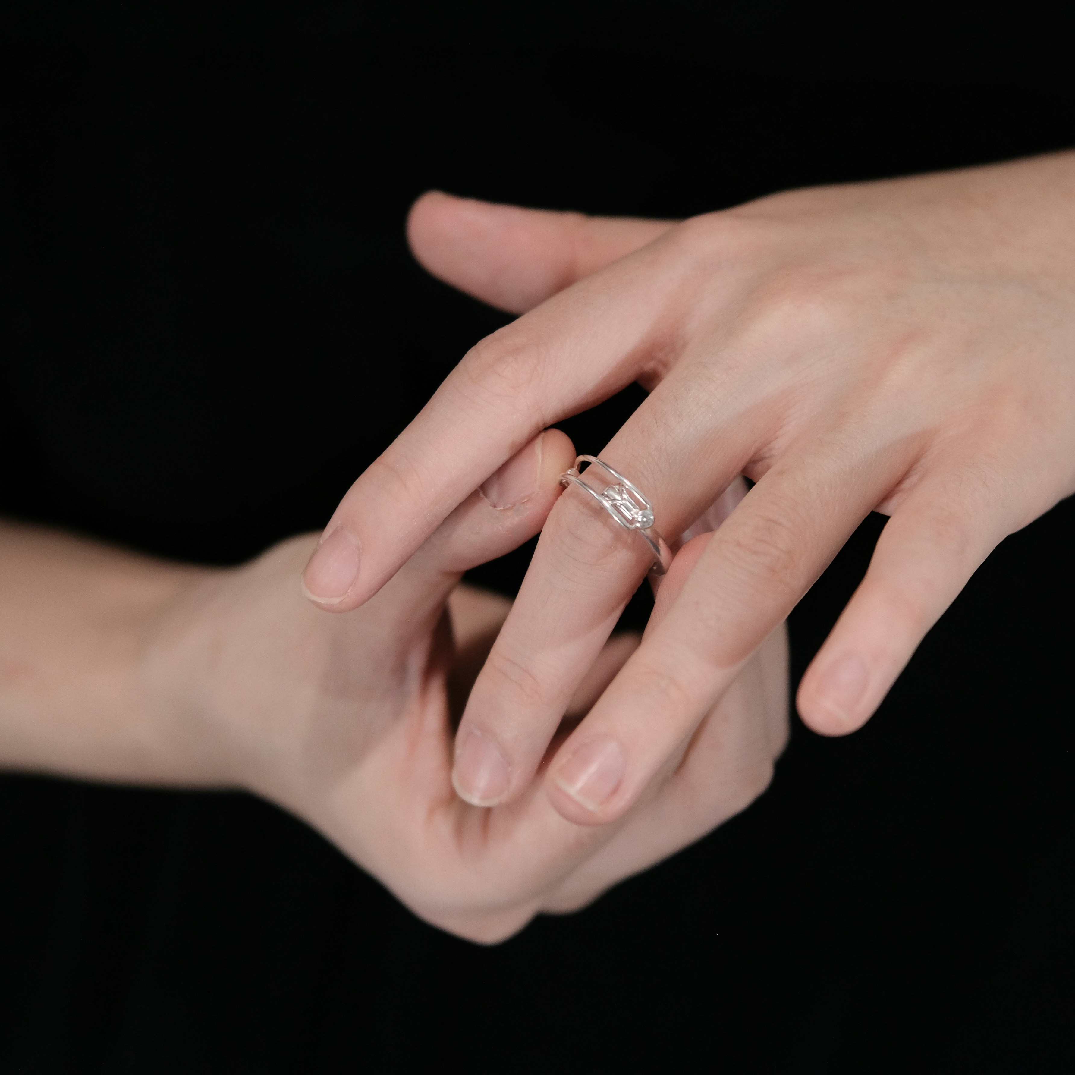 Holding Light: A Diamond Ring Framed by Gentle Hands