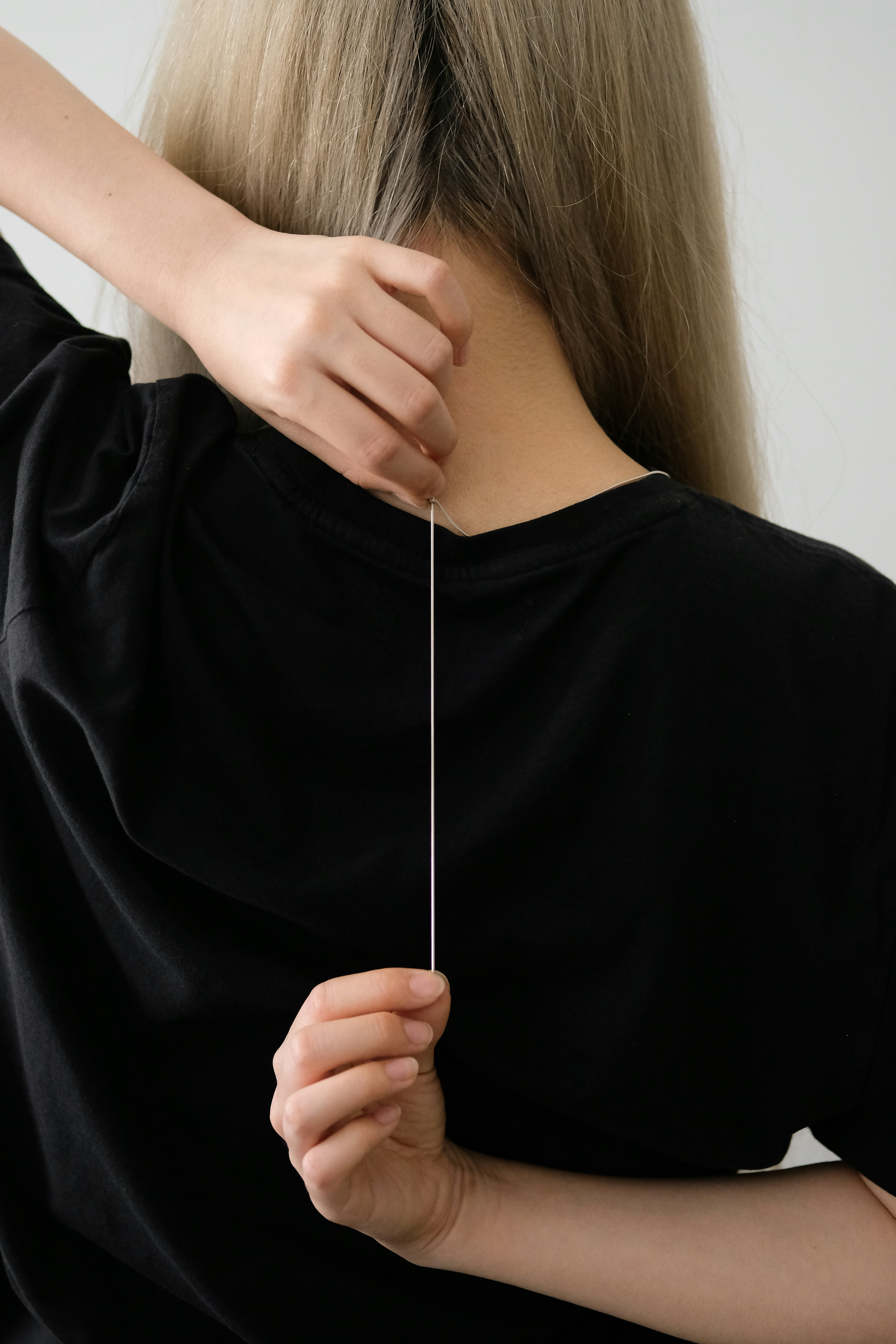 Thread of Focus: A Back Portrait with a Slender Wire as the Quiet Center
