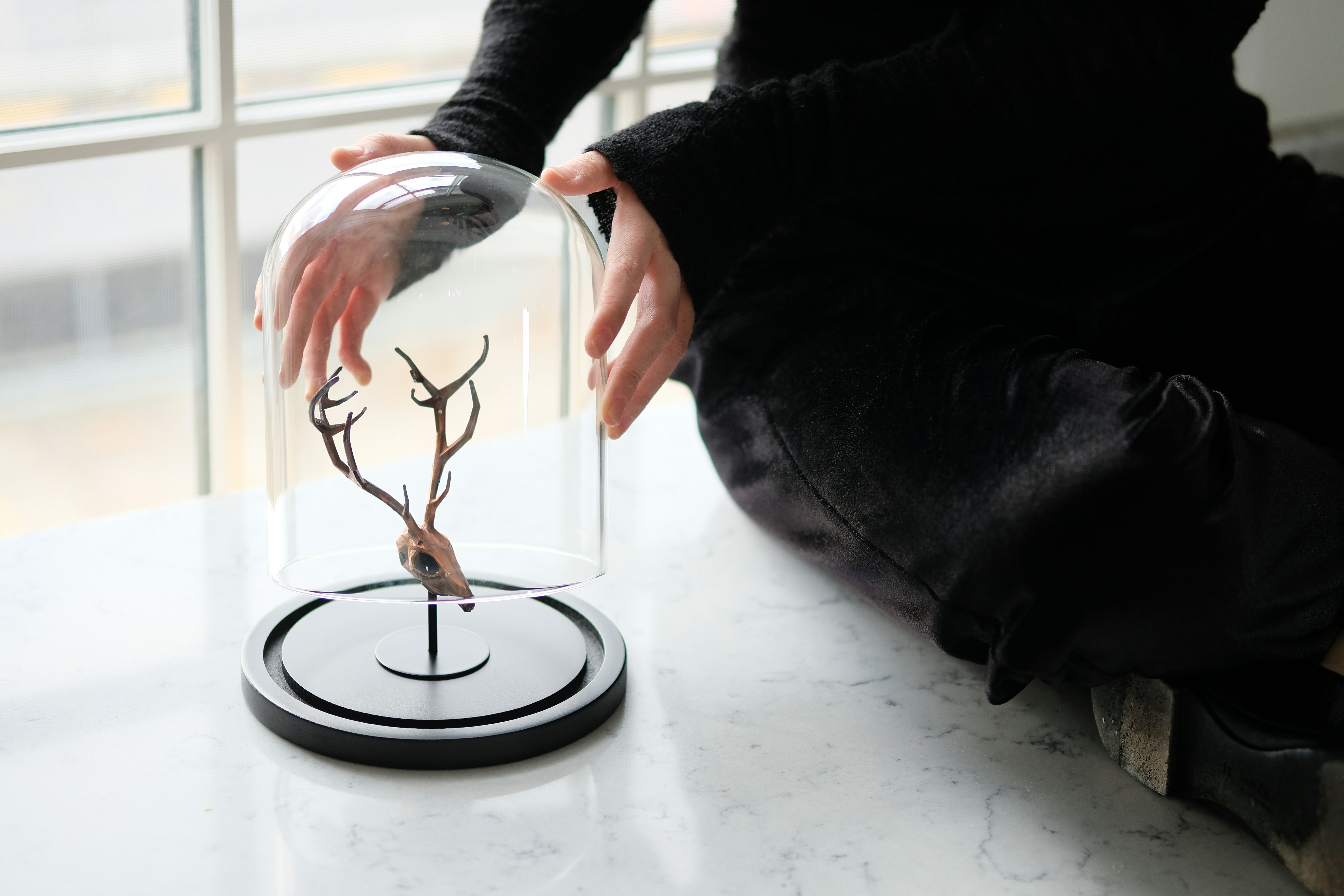 Glass Dome, Quiet Hands: A Delicate Reindeer in a Snowlit Display