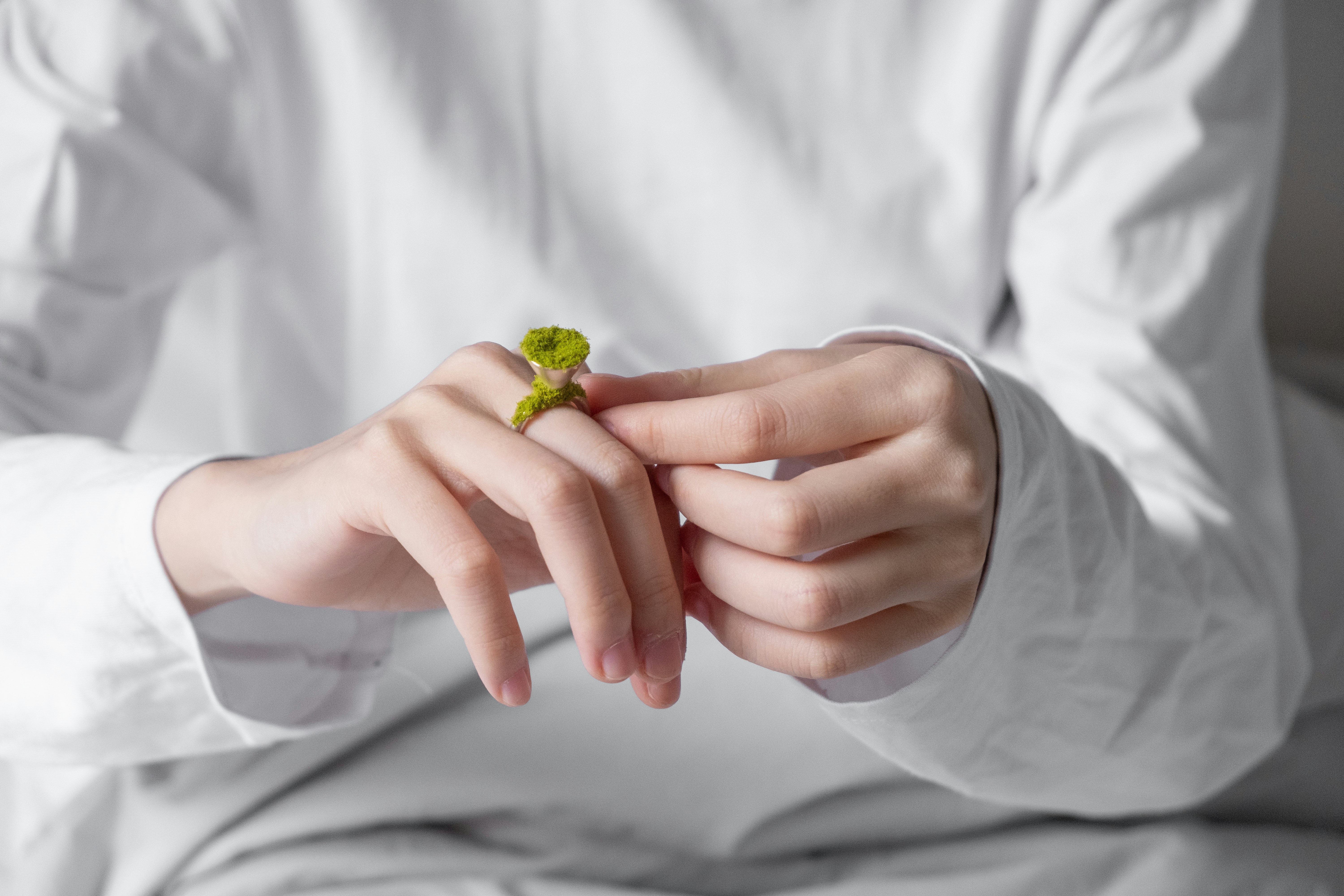 Bent Gentle Hands: A Close-Up of a Tiny Leaf Held Between Fingers
