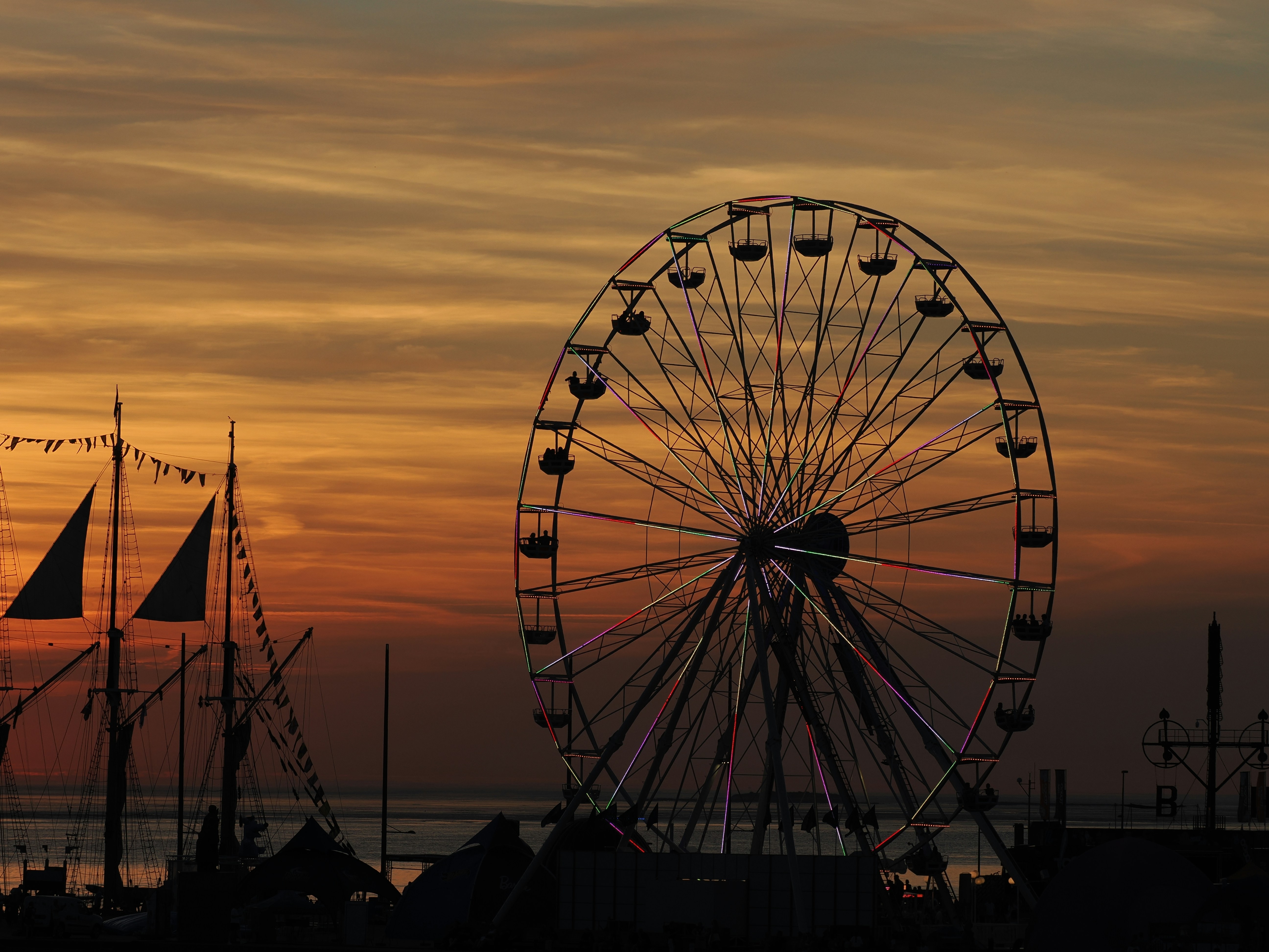 Sunset Wheel: A Silhouette of Joy on the Pier