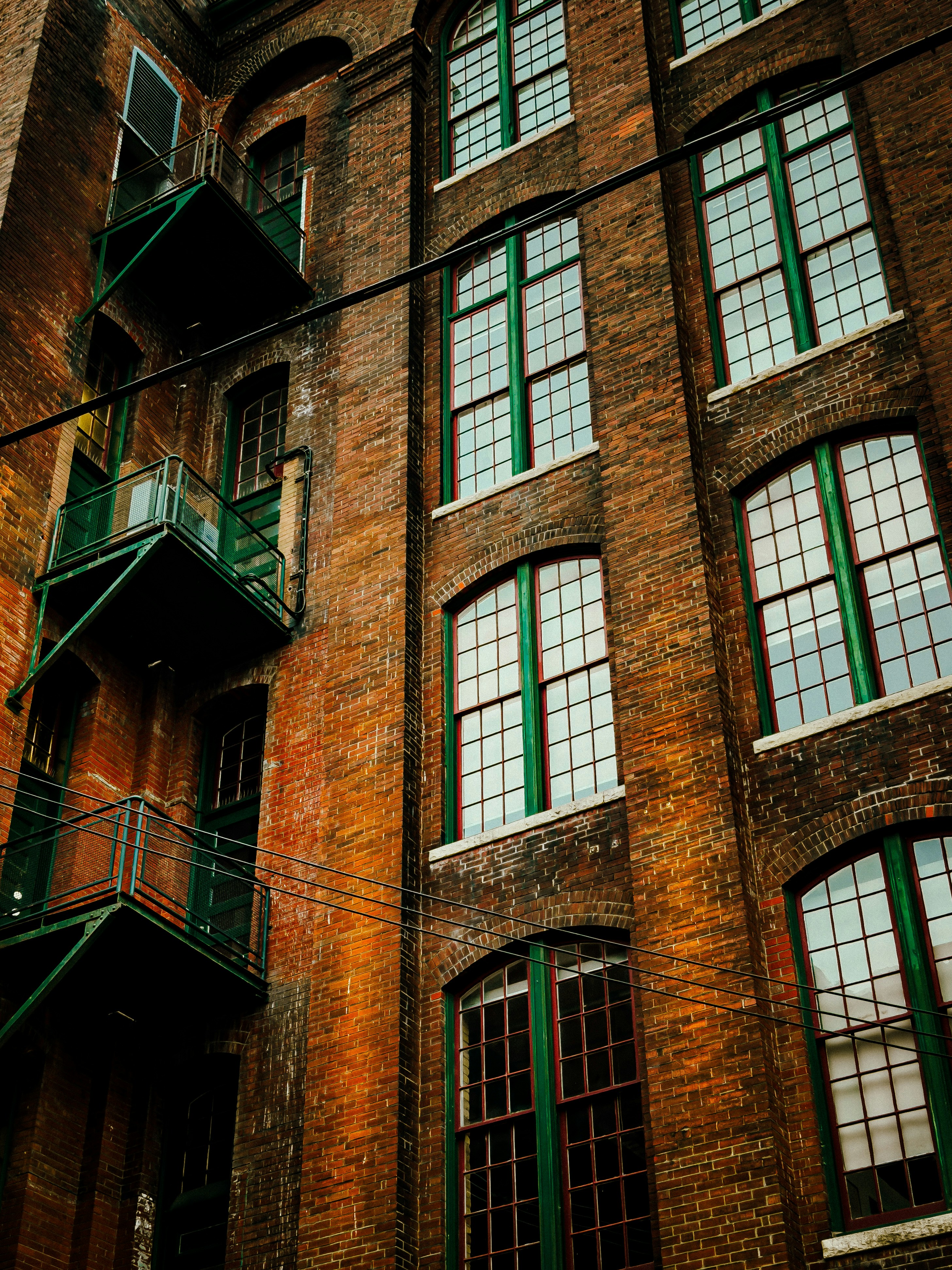 Brick Facade Echoes of Steel: An Urban Wedge of Windows and Fire Escapes