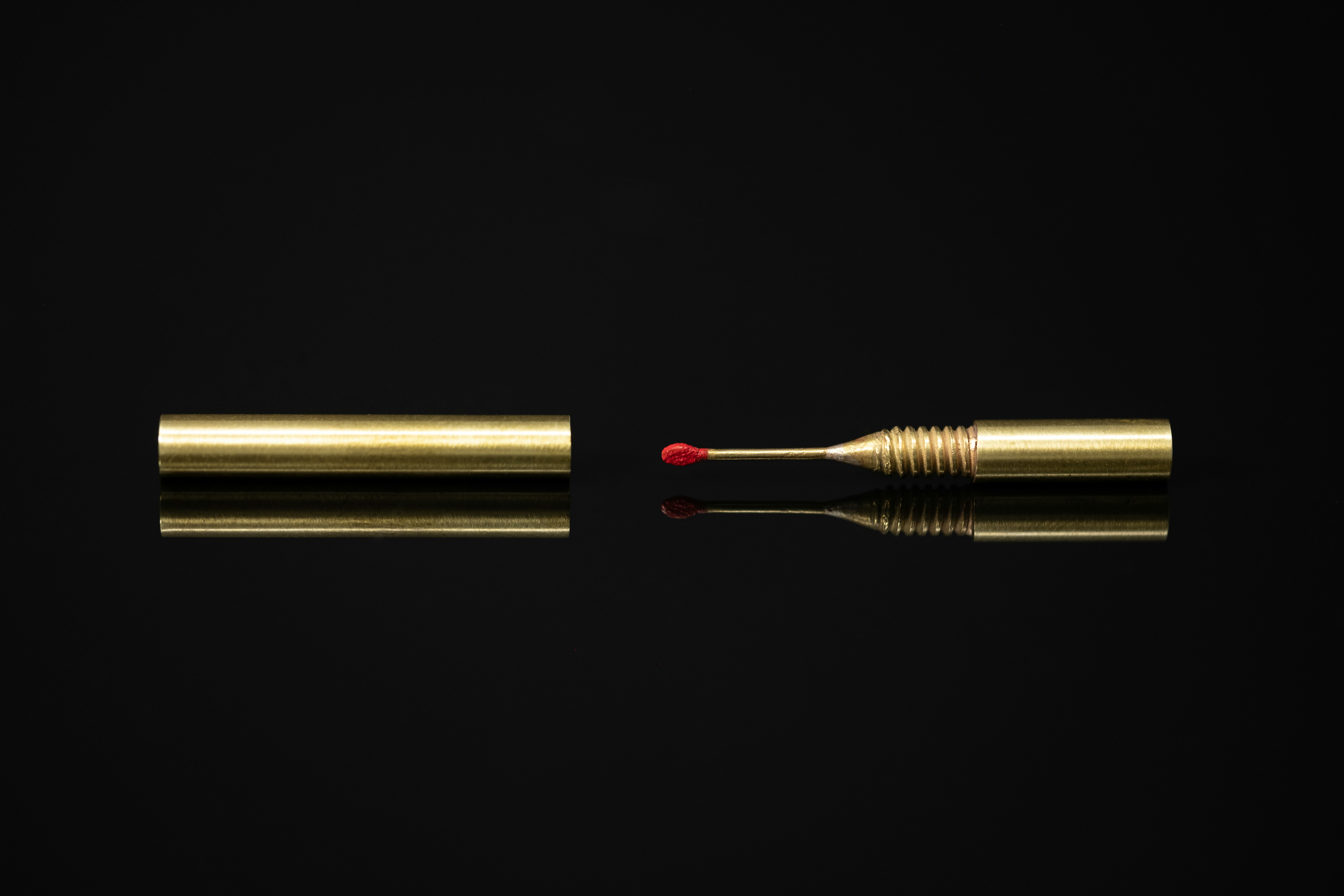 Brass Lipstick Divider: A Minimalist Moment in Glossy Darkness