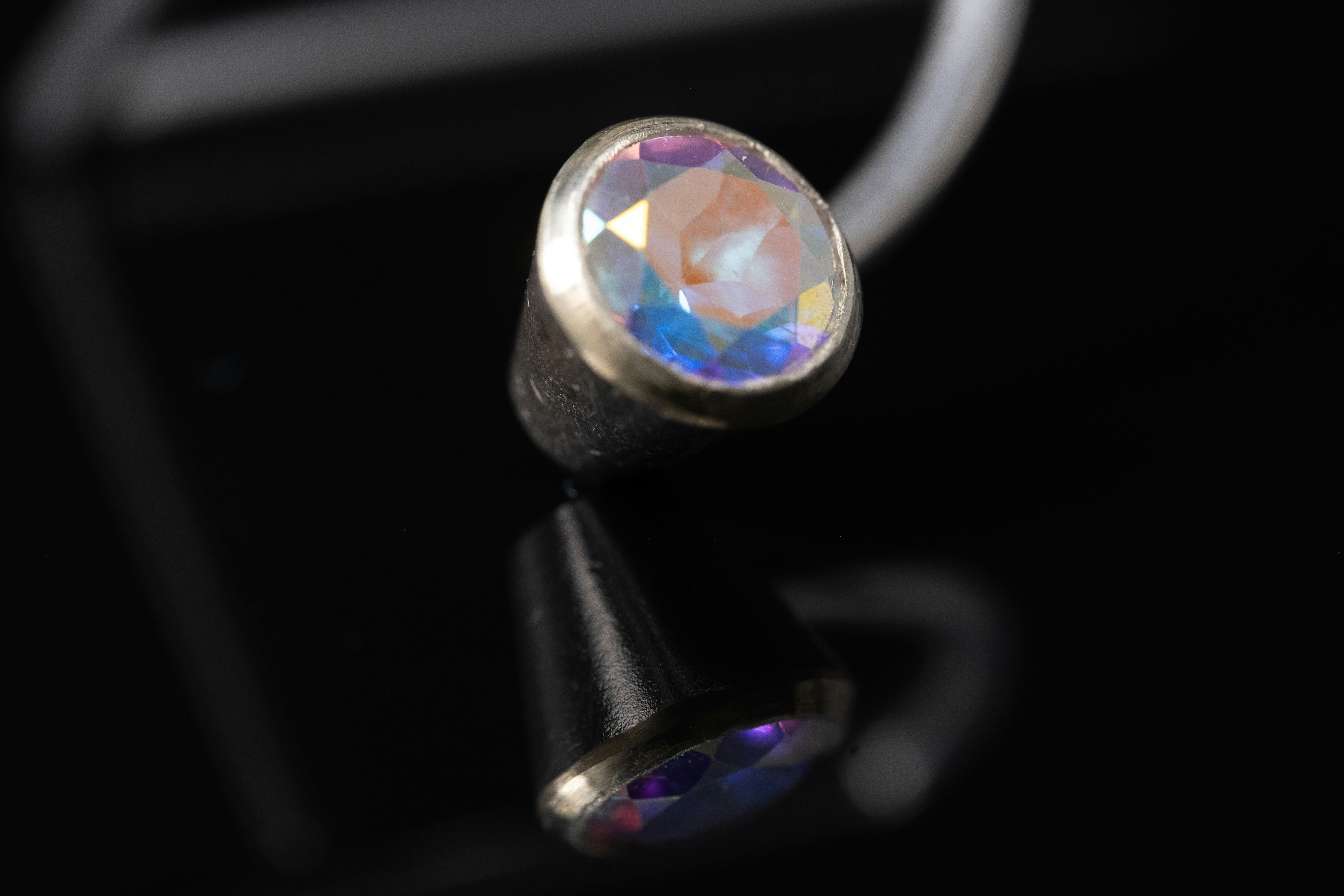 Prismatic stud on a reflective black surface