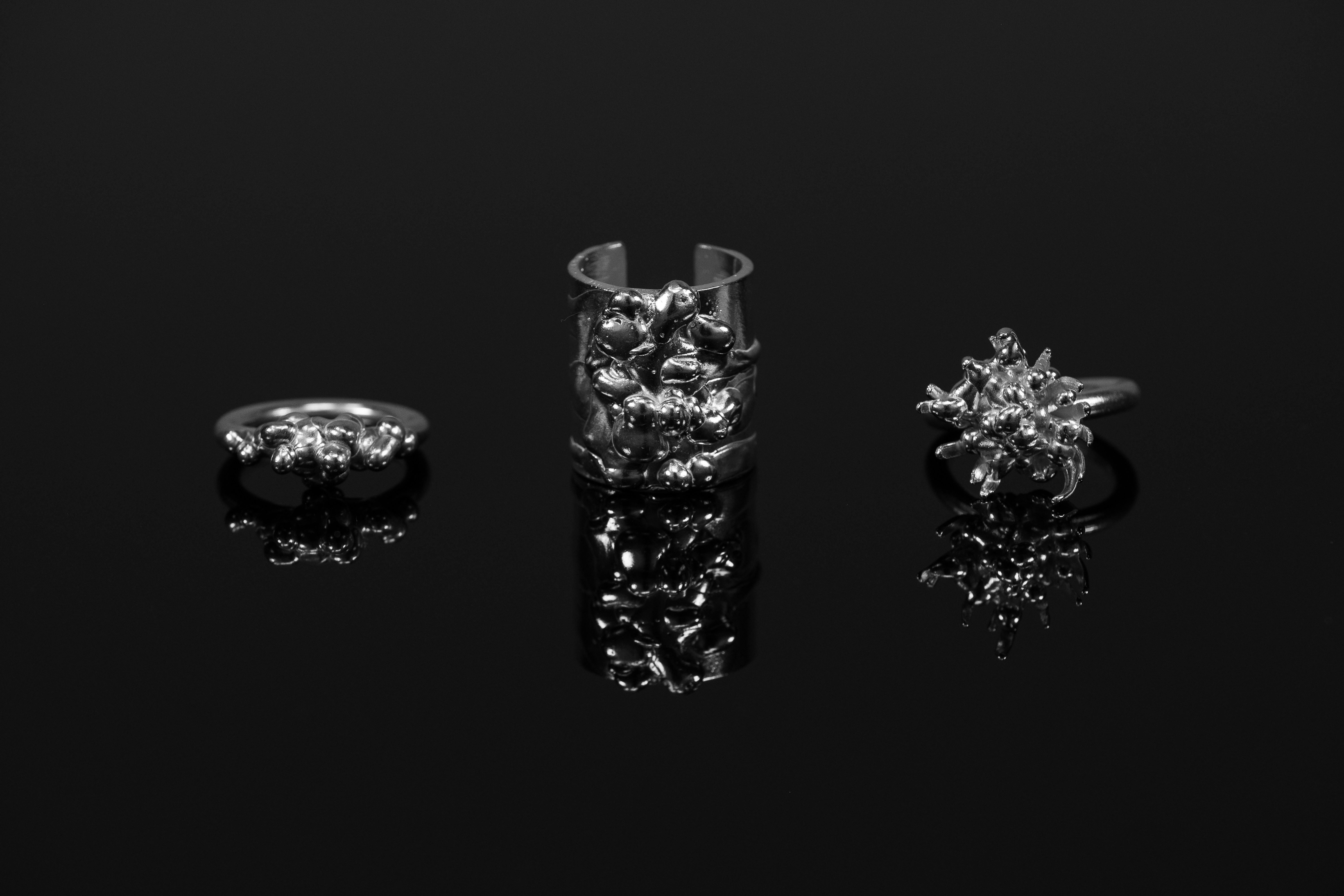 Reflections in Onyx: A Trio of Sparkling Rings on a Midnight Backdrop
