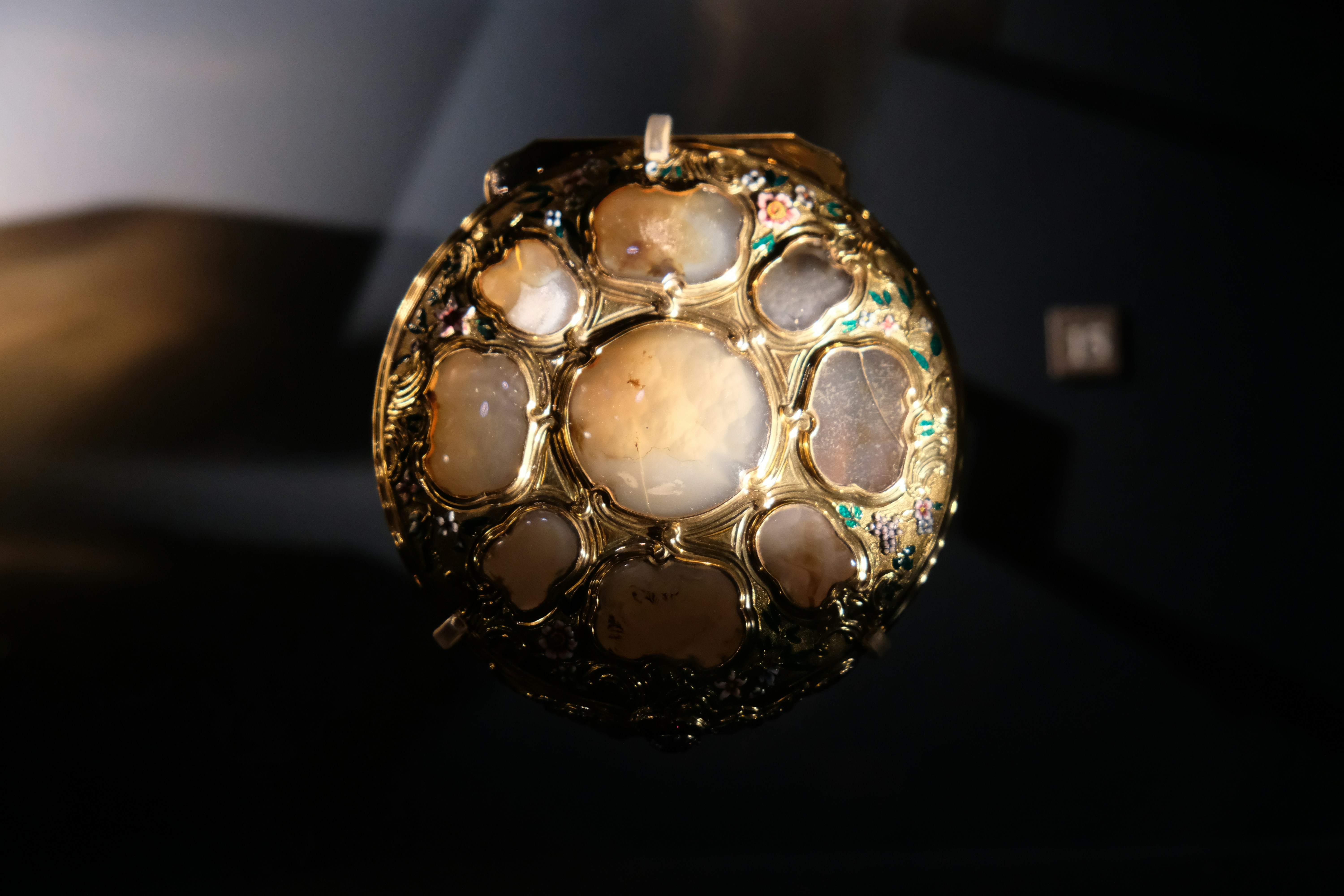 Moonlit Halo: a gold inlaid gemstone pendant suspended in darkness