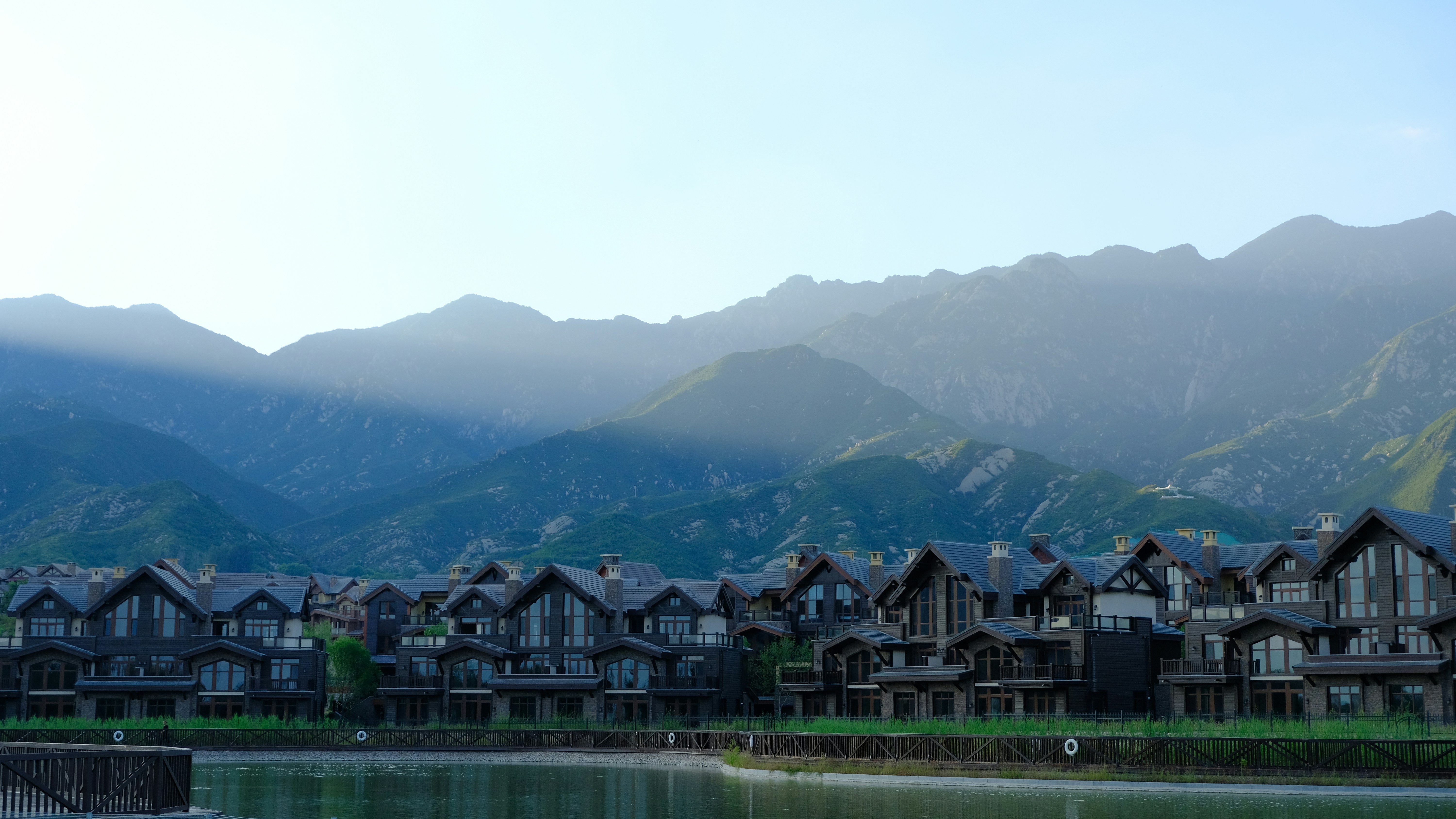 Row of Alpine Townhouses Under a Serene Mountain Ridge