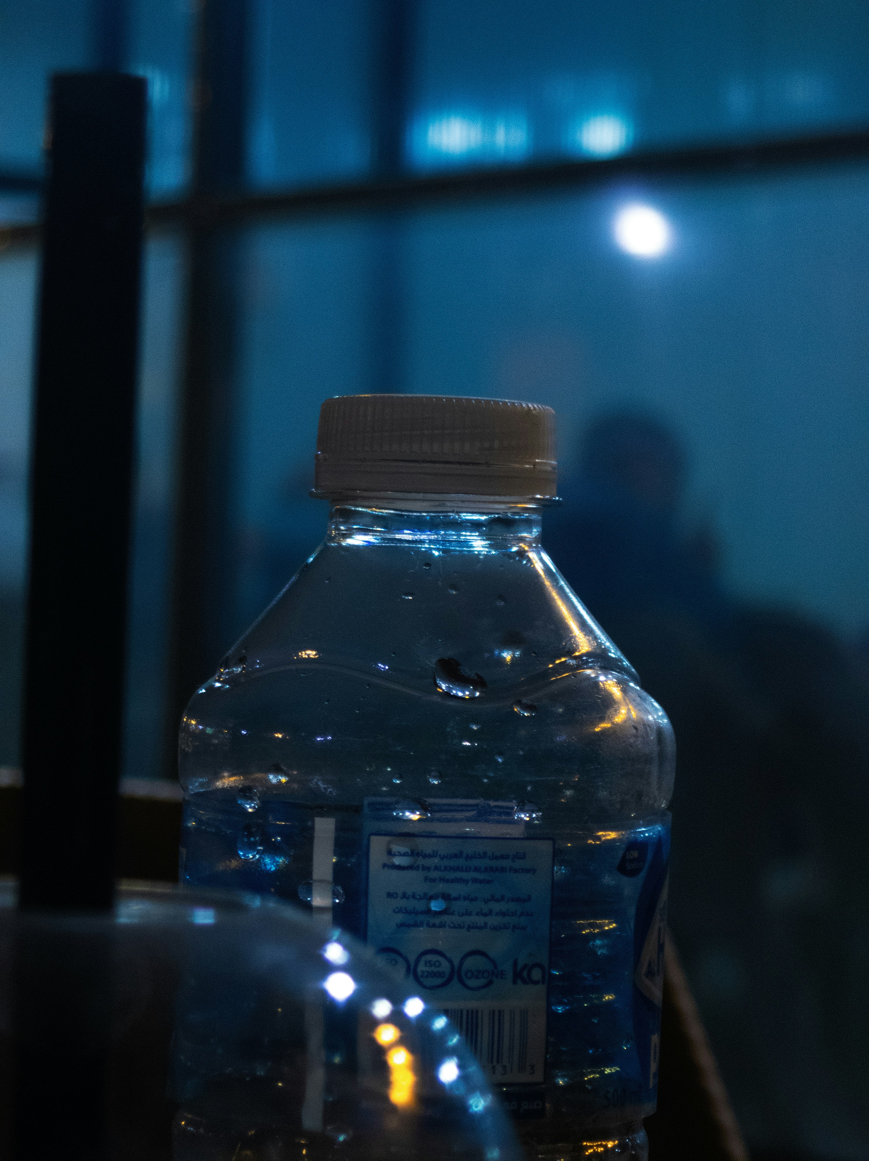 Blue-tinted Bottle in Low-Light Studio
