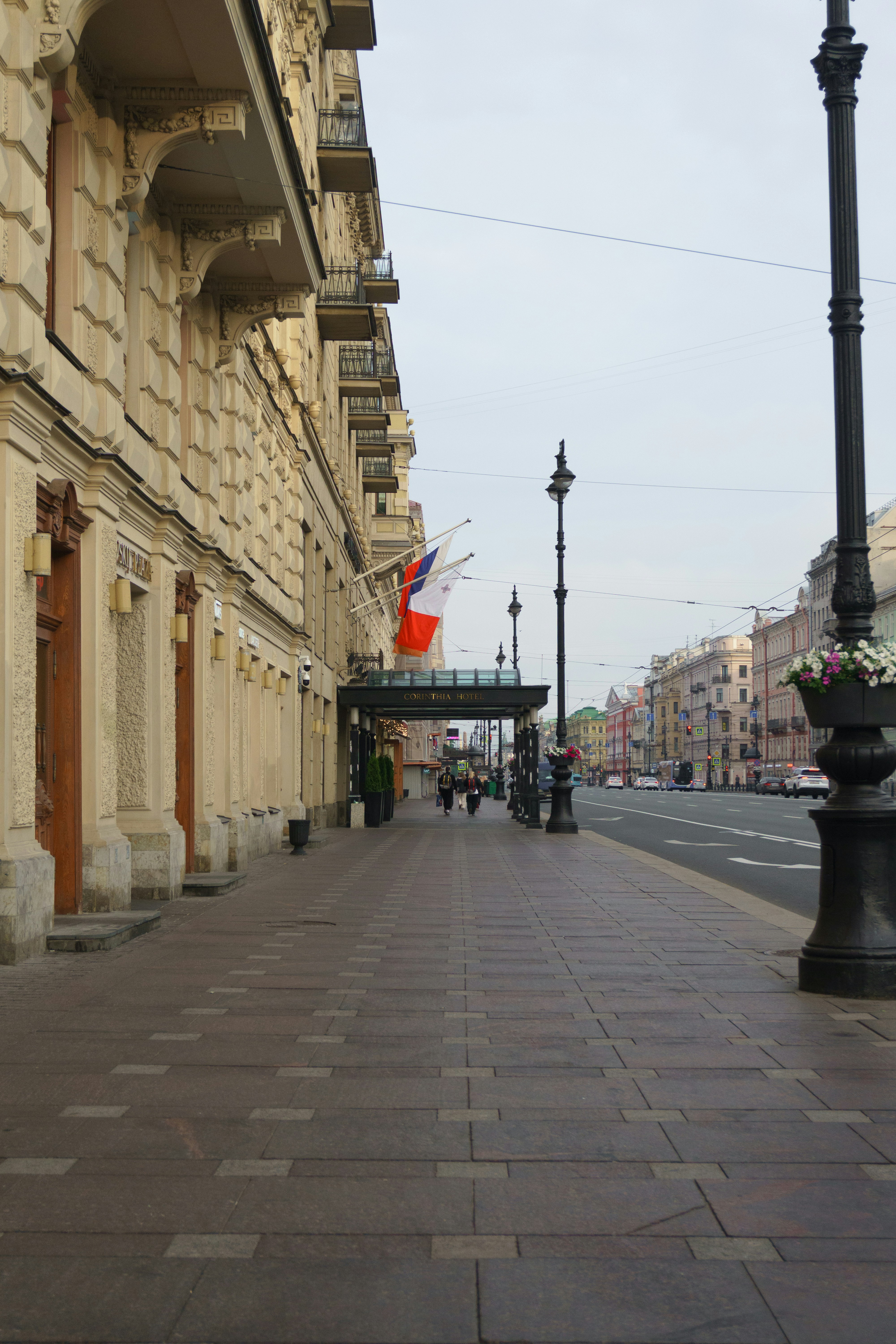 A City’s Quiet Boulevard: Flag, Lanterns, and Morning Light