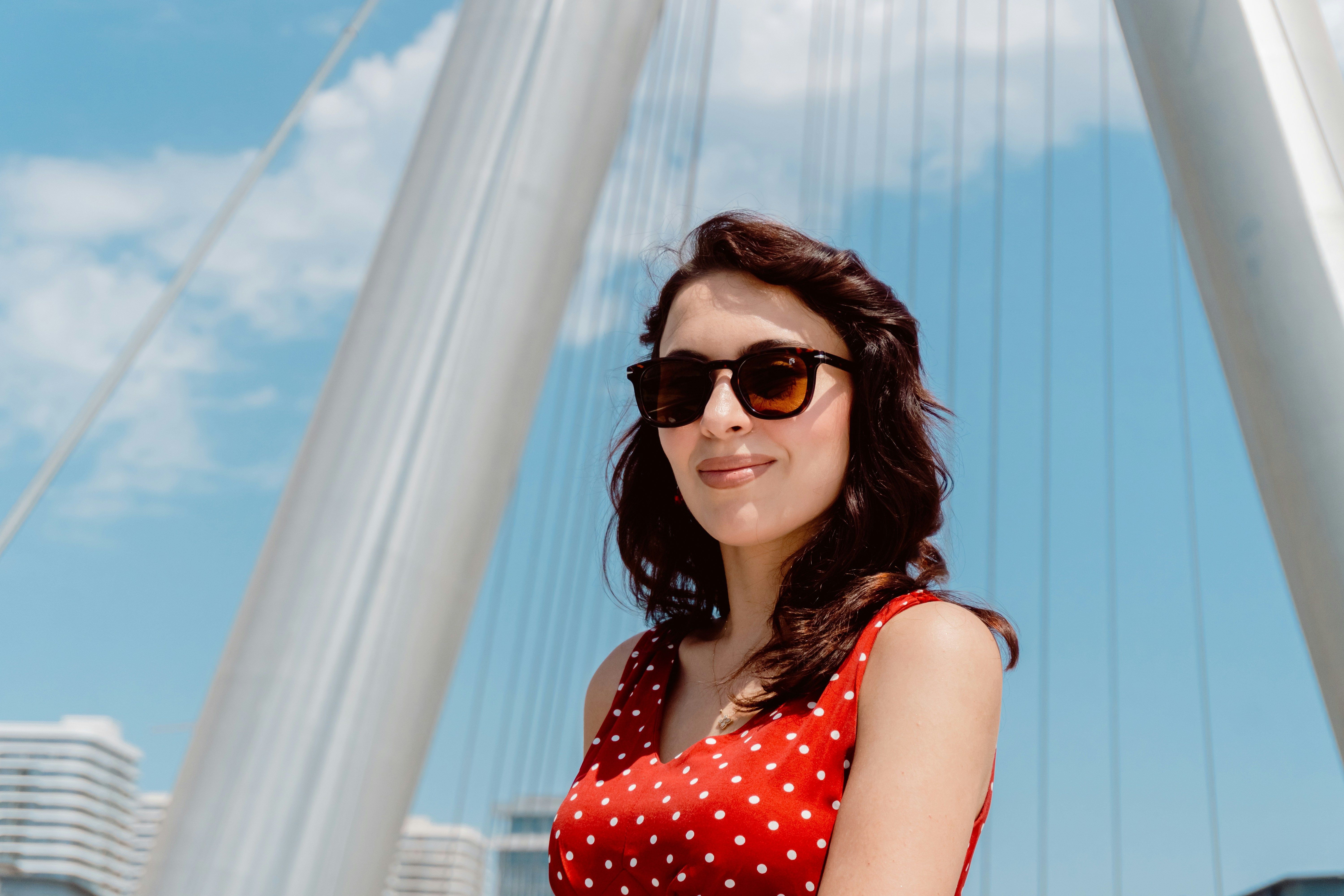 Polished selfie on a sunlit bridge with polka-dots