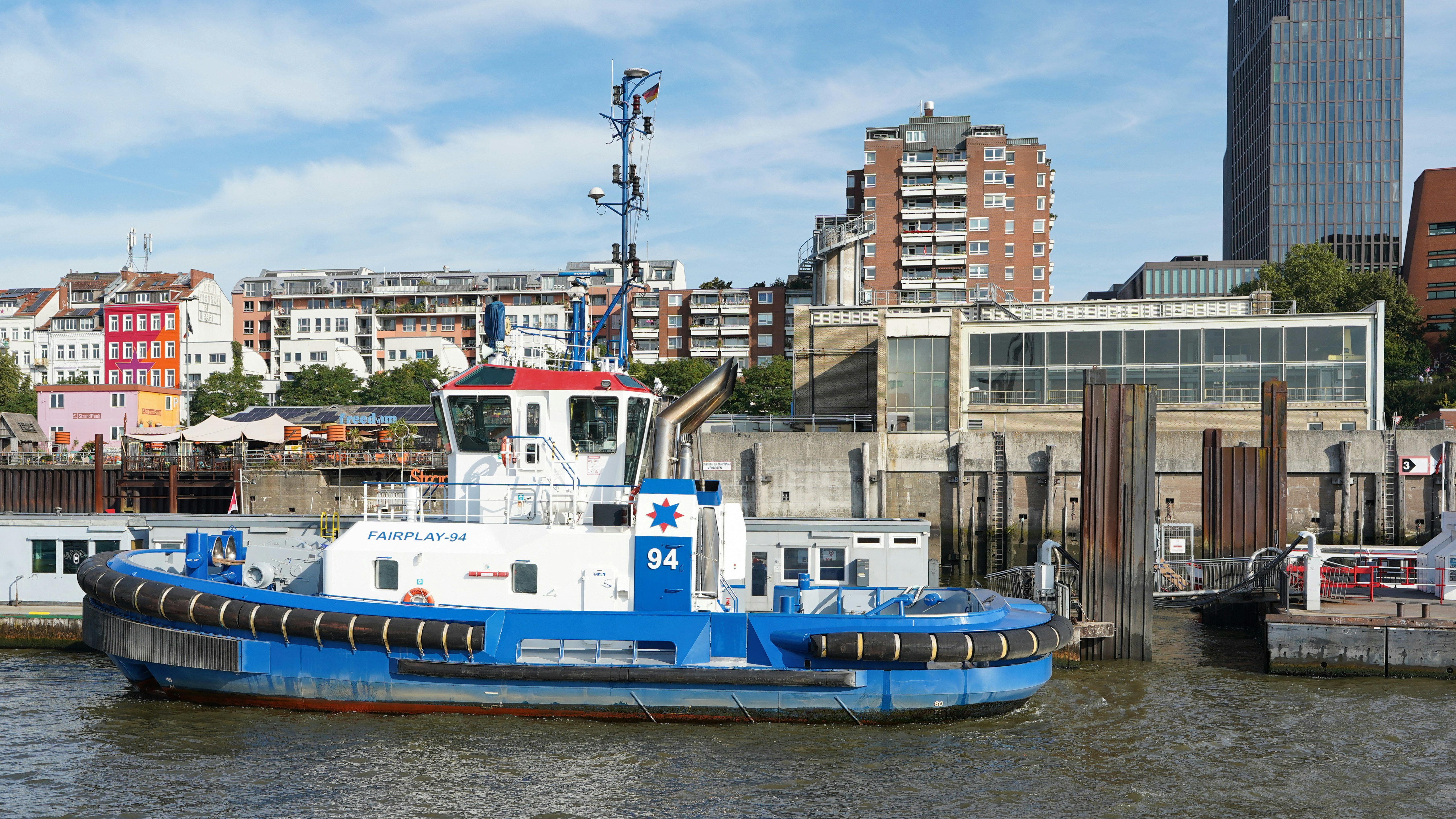 Blue Tugboat at a Waterfront Pier