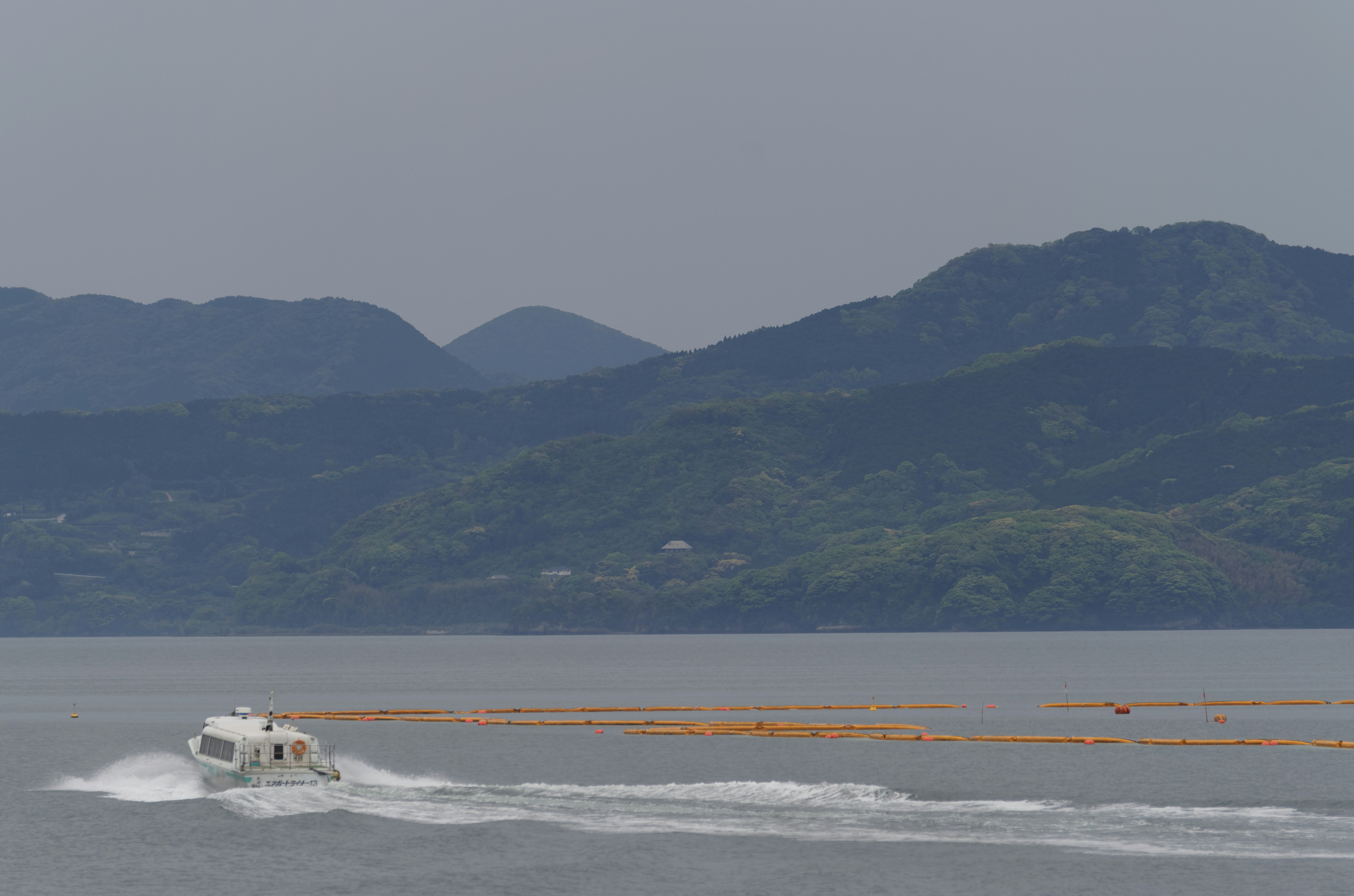Orange-barrelled Vessel Skimming a Calm Seascape