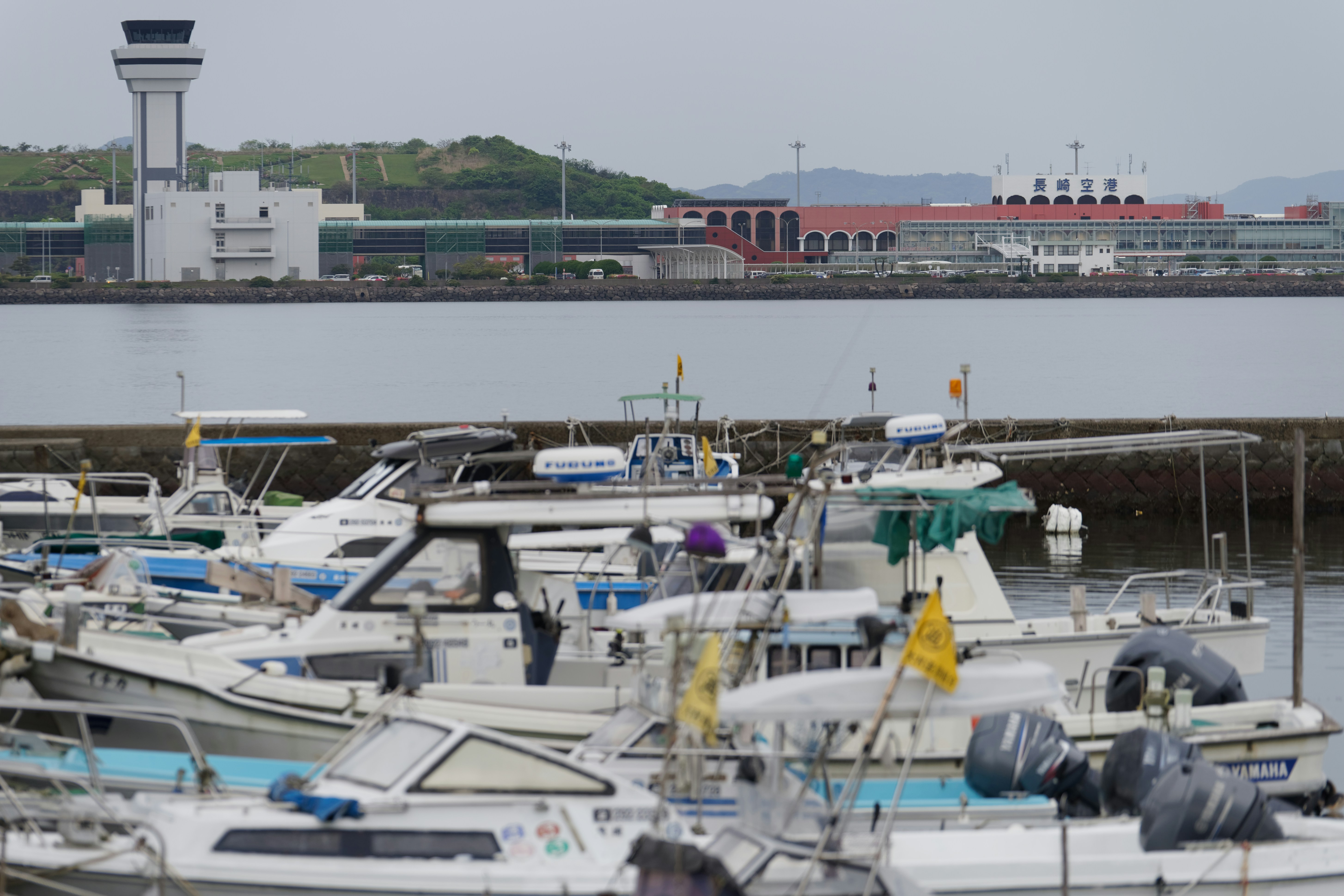 Marina Facade: Boats in the Foreground with a Distant Airport Terminal