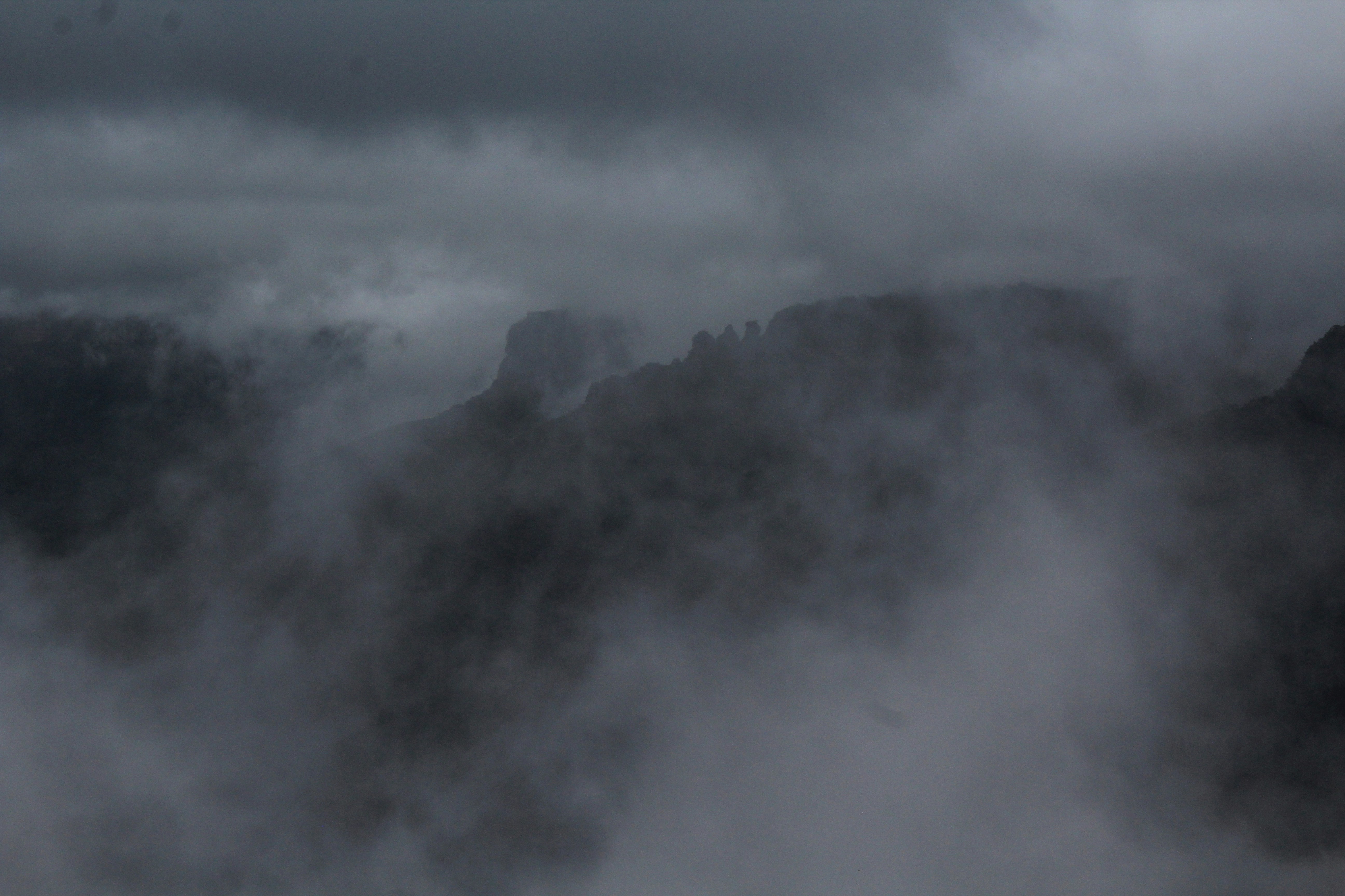 Mist-enshrouded Ridge Under Dark Clouds