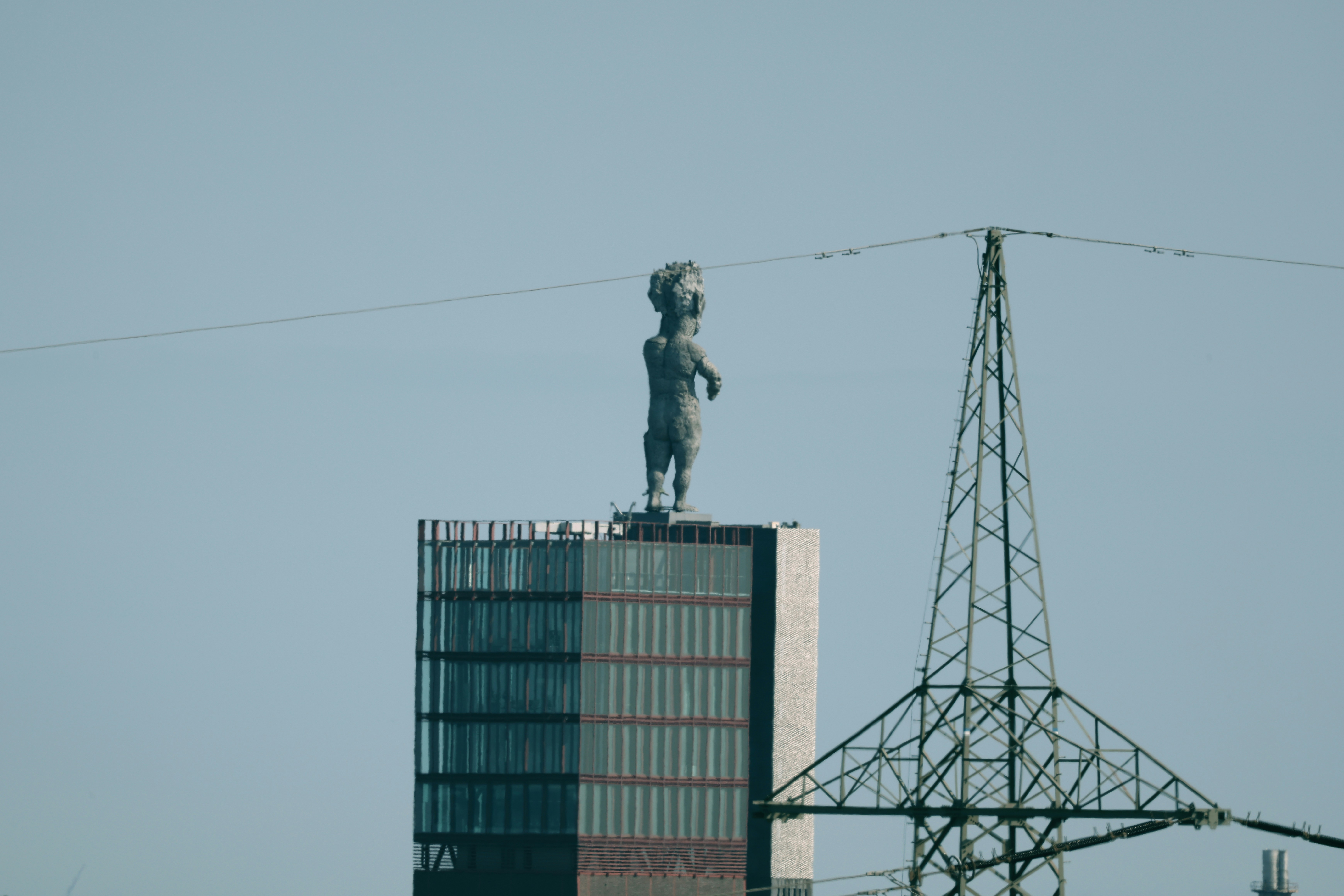 Statue Crowned by Skyline: A Summit Above Steel and Glass