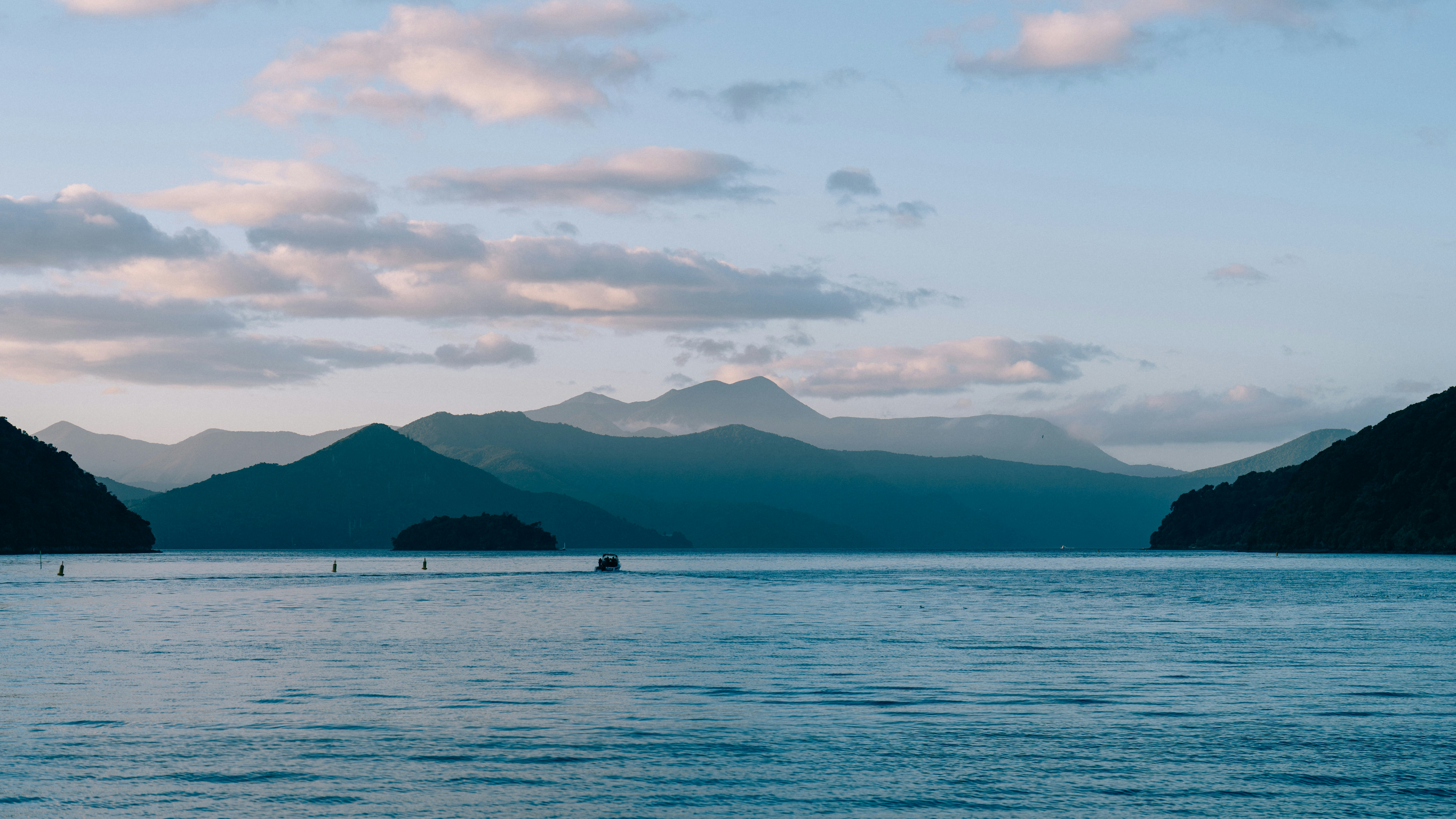 Calm Horizon: Layers of Mountain Silhouettes Over a Tranquil Sea