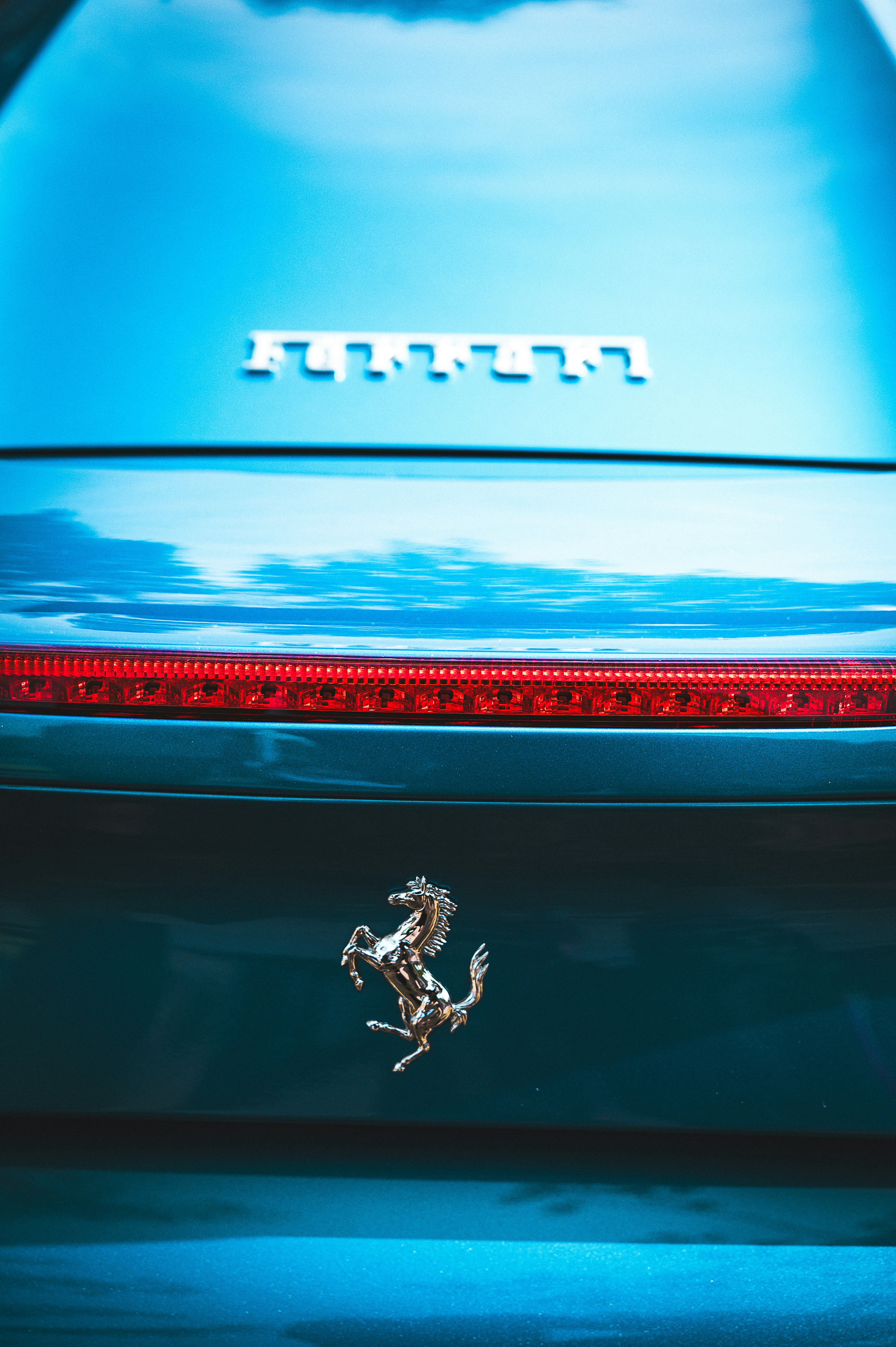 Prancing Power: Rear Emblem of a Blue Ferrari