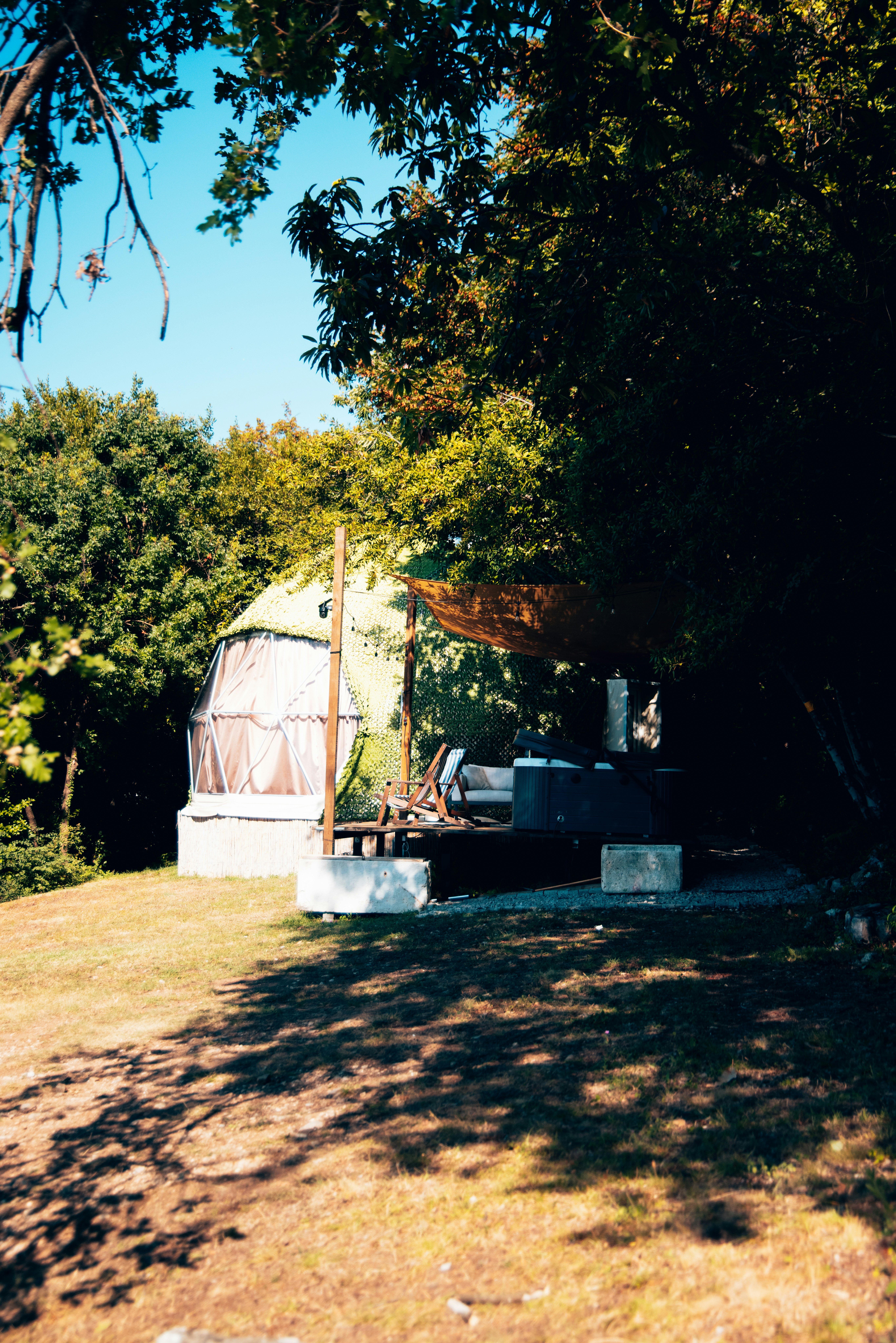 Sunlit Campside with a Tarped Deck and Yurt Backdrop