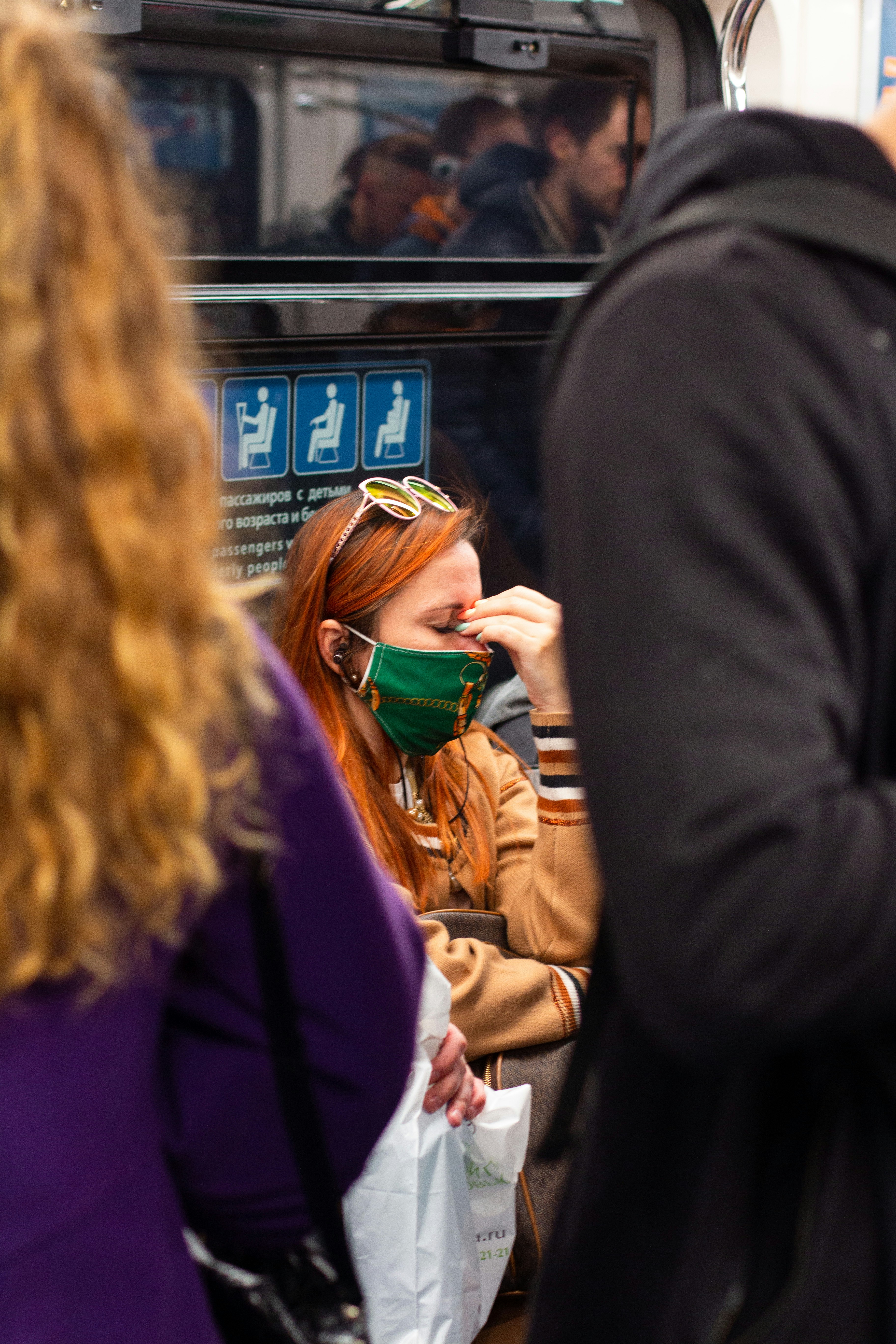 Green-Masked Focus: A Moment of Quiet Amid Commuter Flow