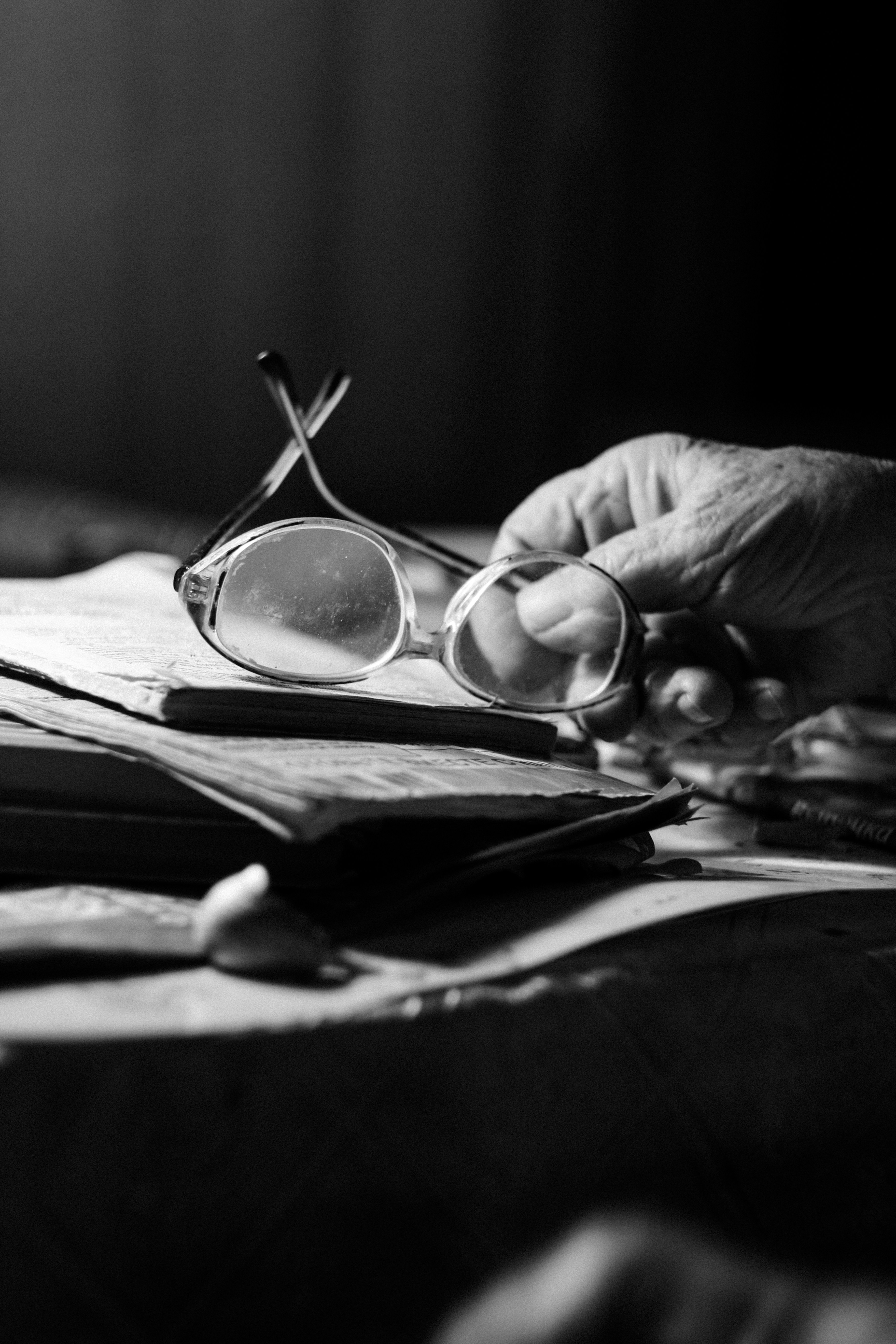 Glasses on a Weathered Desk: Quiet Focus Amid Paperwork