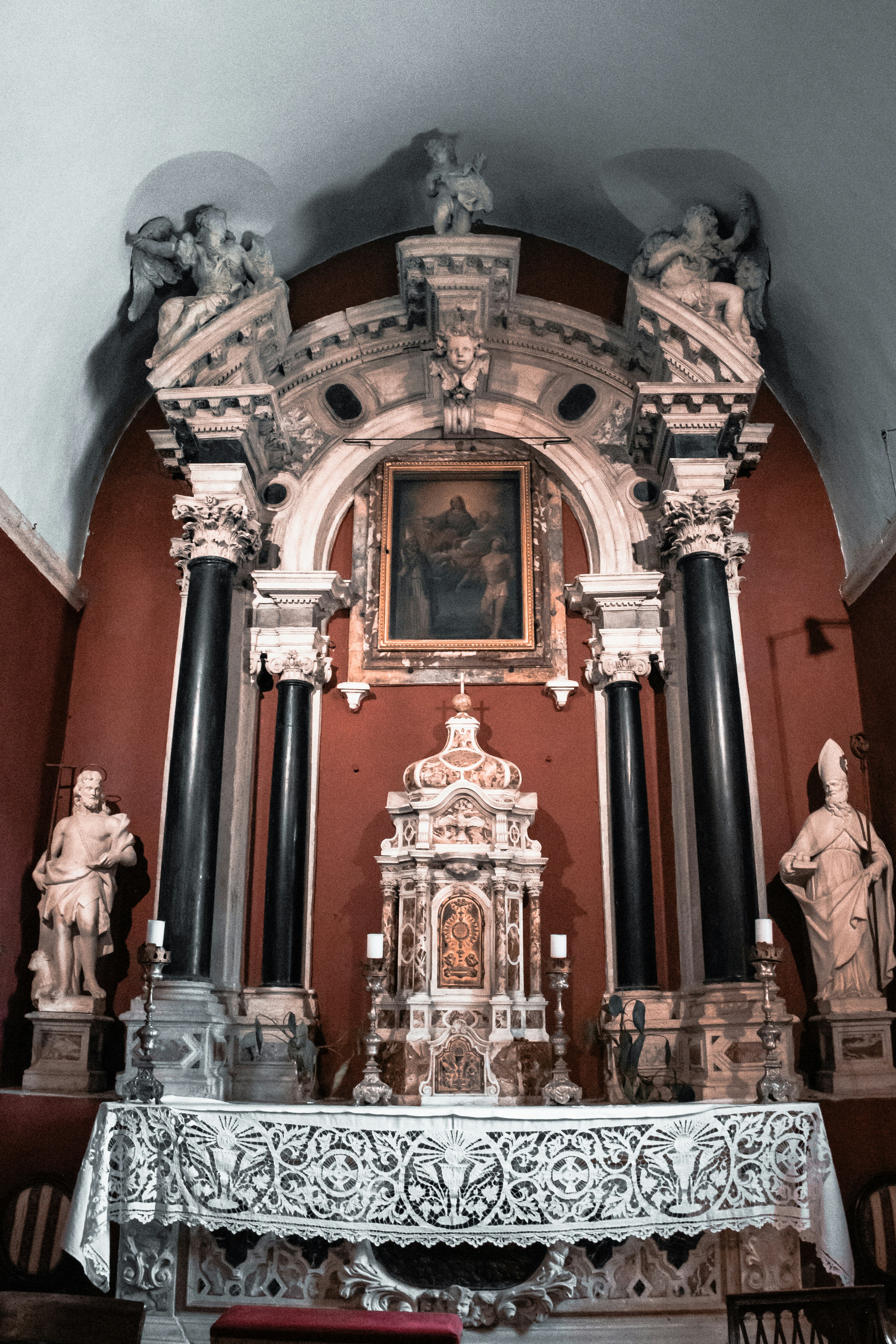 Ornate chapel altar framed by towering columns under a stone arch