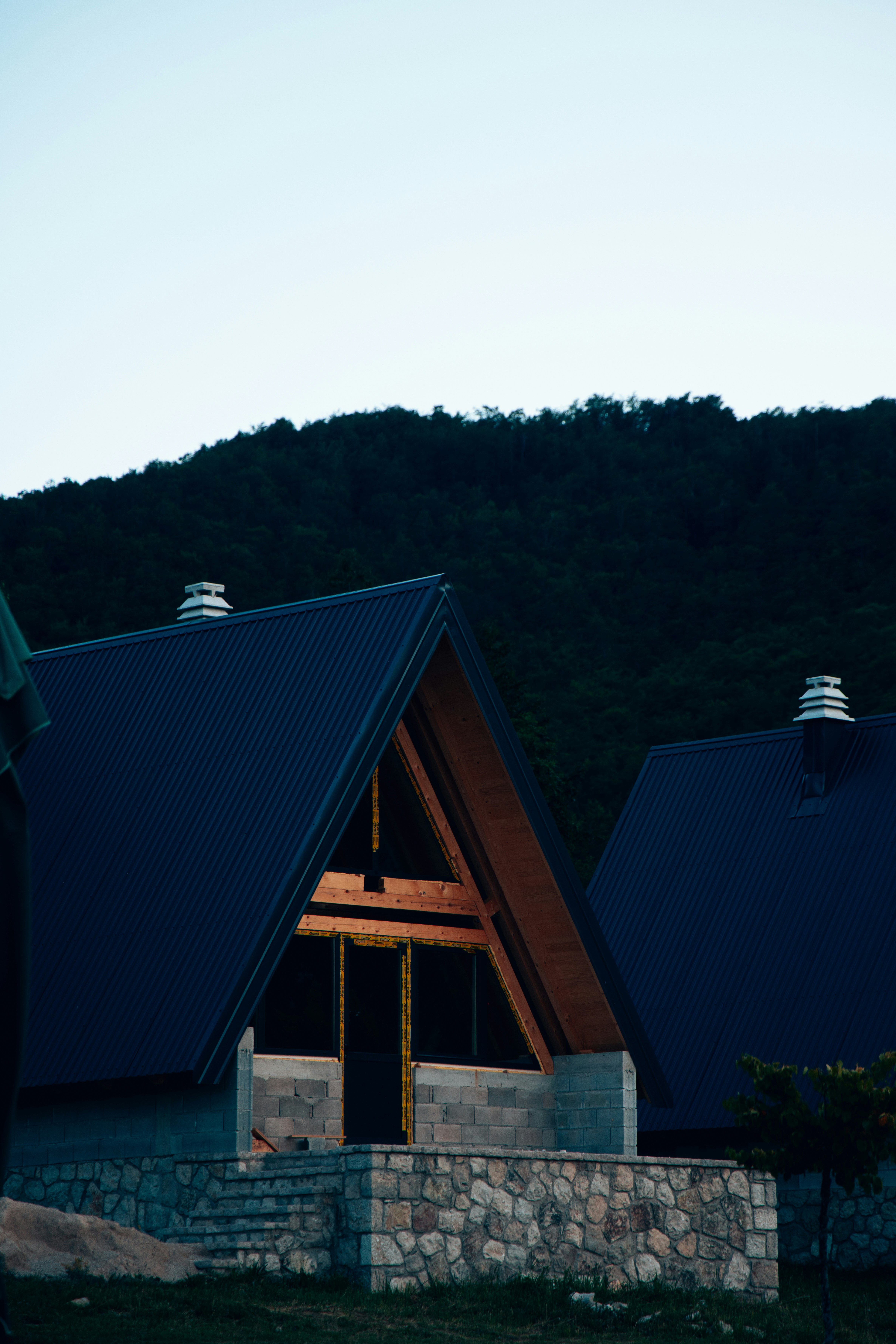 A Quiet Gablescape: Cabin Roofs Nestled Against a Timbered Ridge
