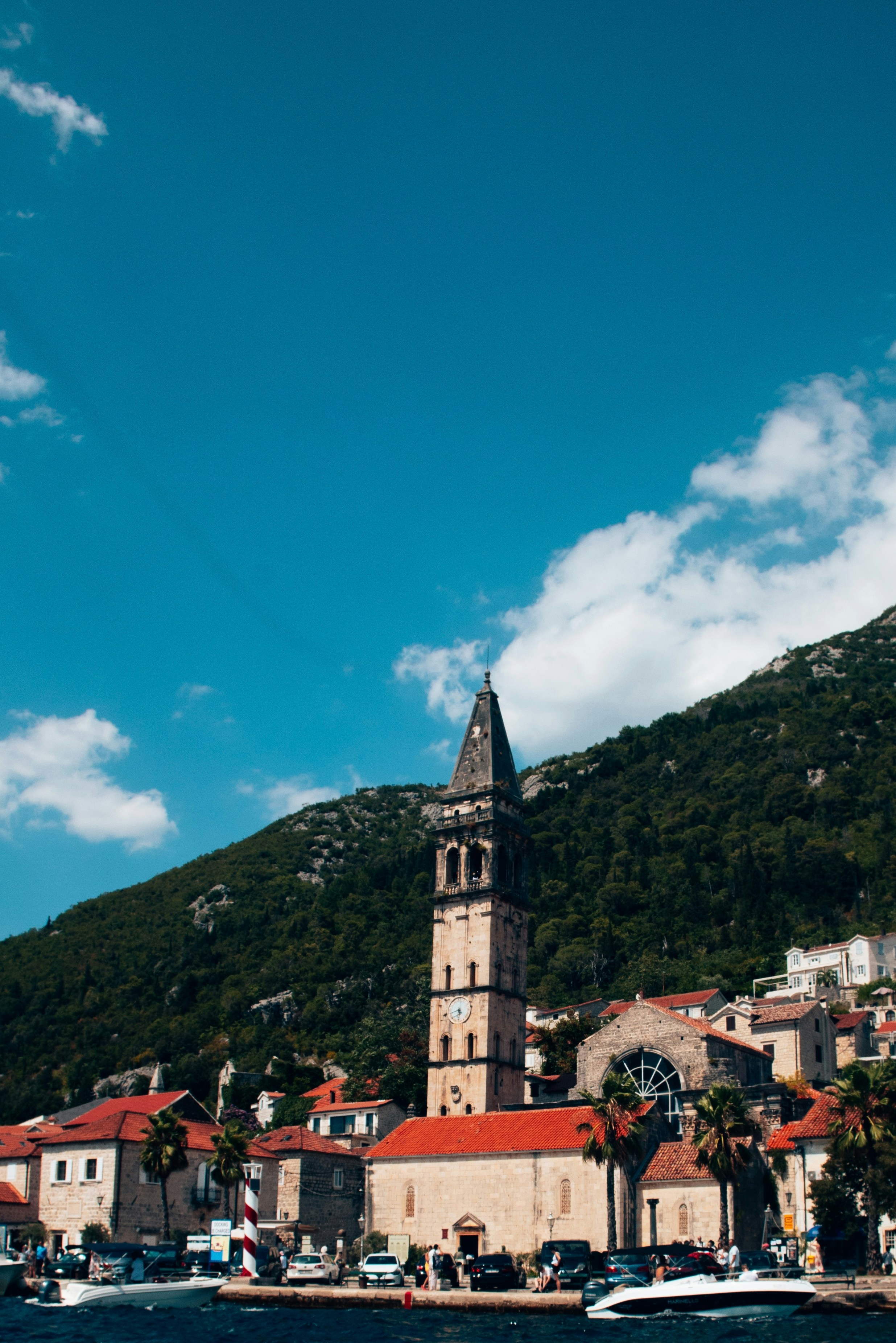 Harbor Town Bell Tower Rising Above Red-Tiled Row Houses