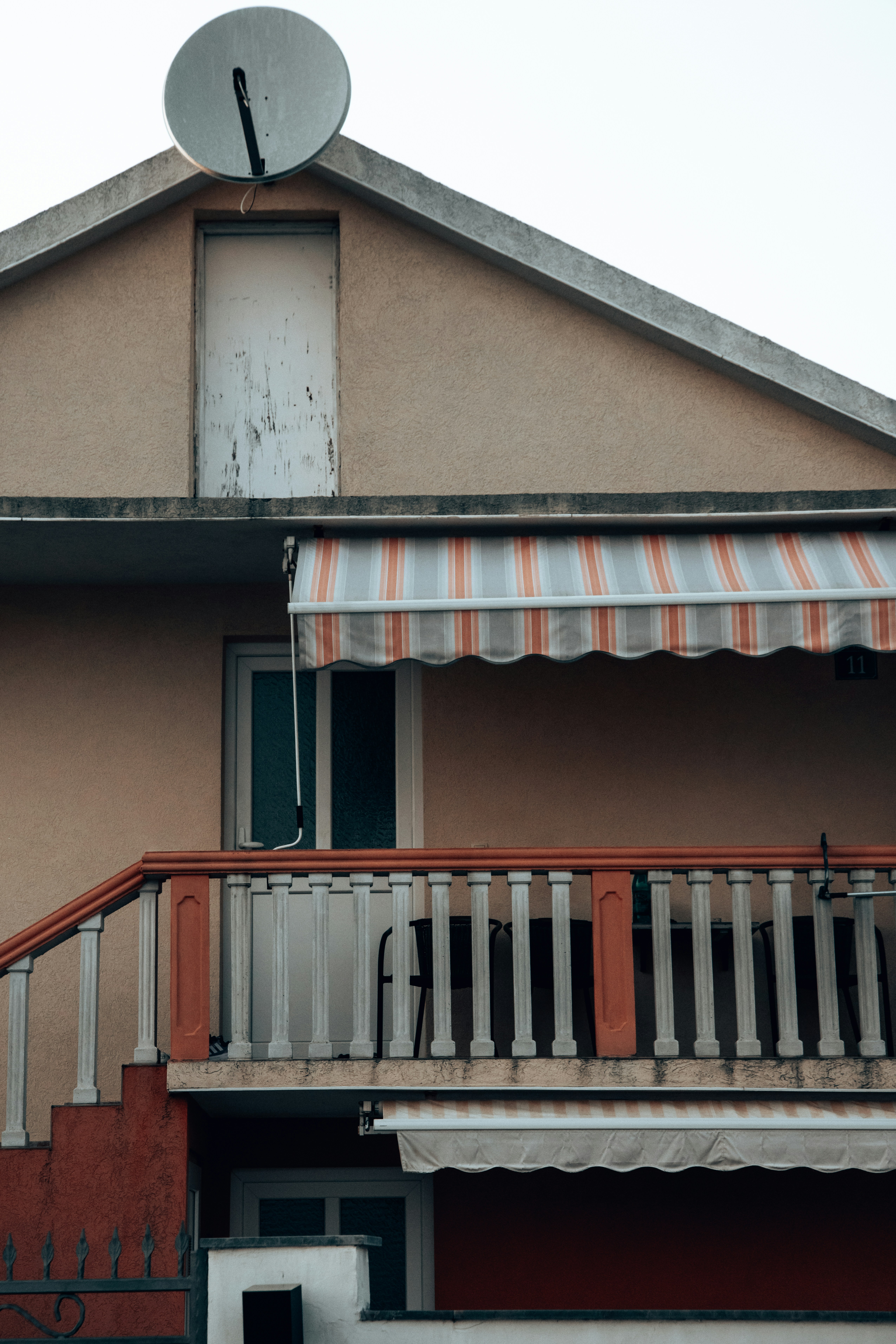 Terrace Echoes: A Pastel Facade Under a Striped Canopy