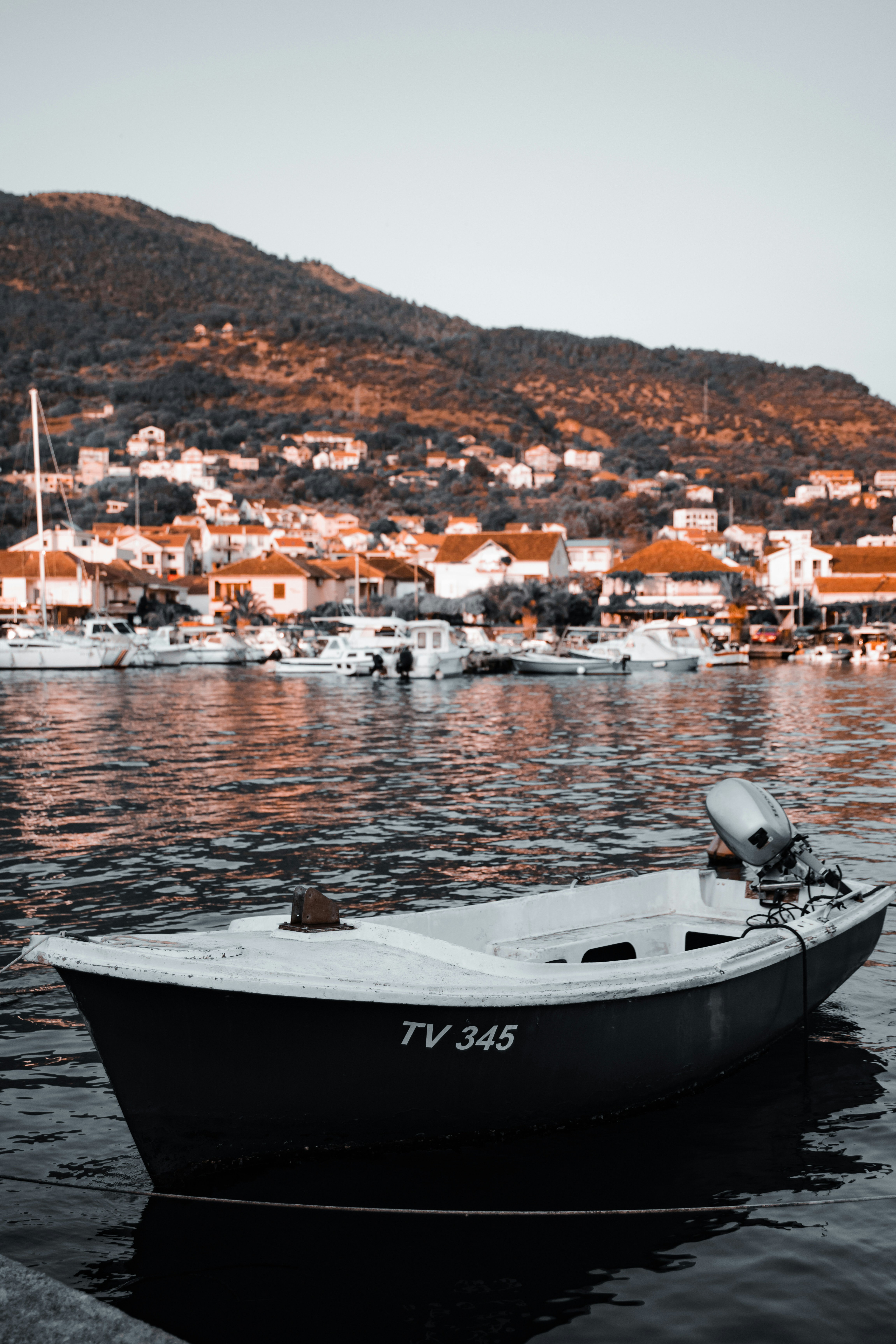 Harbor Boat at Dusk: Quiet Palette Over a Coastal Village