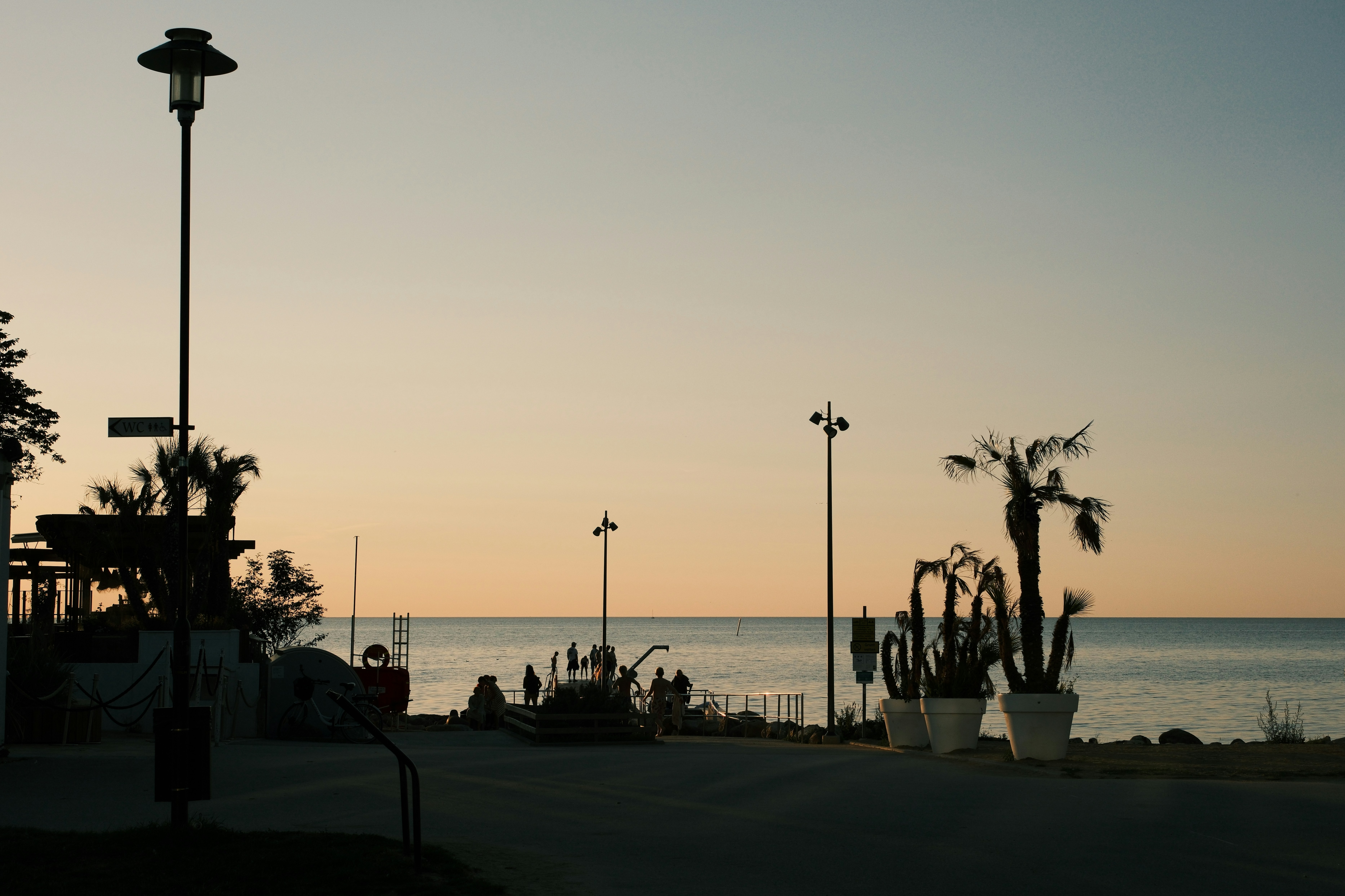 Sunset Over the Promenade: Silhouettes by the Sea