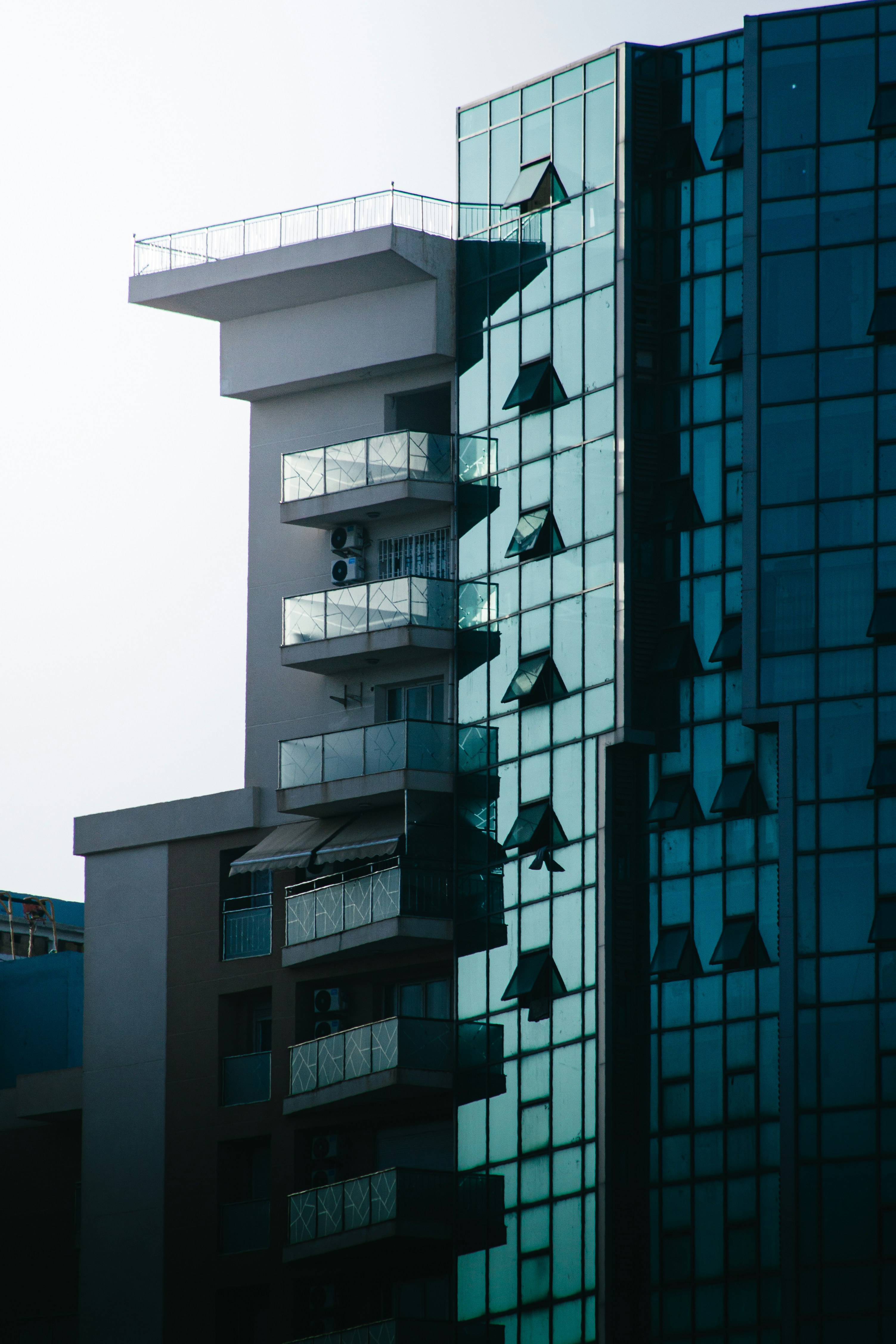 Vertical Glass Facade: Reflections and Stacked Balconies in Urban Light