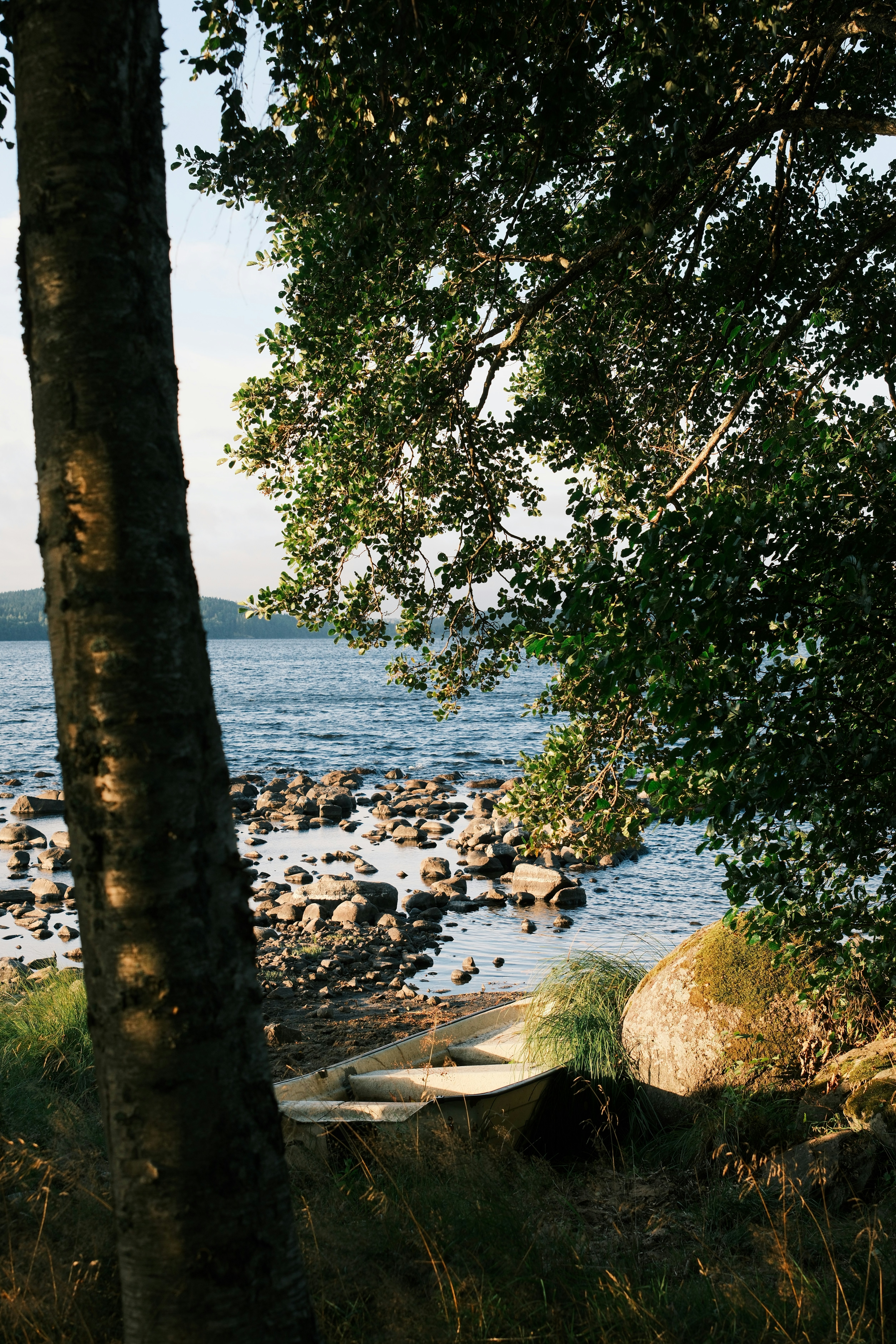 Boat Resting Between Rocks: A Quiet Lakeside Moment