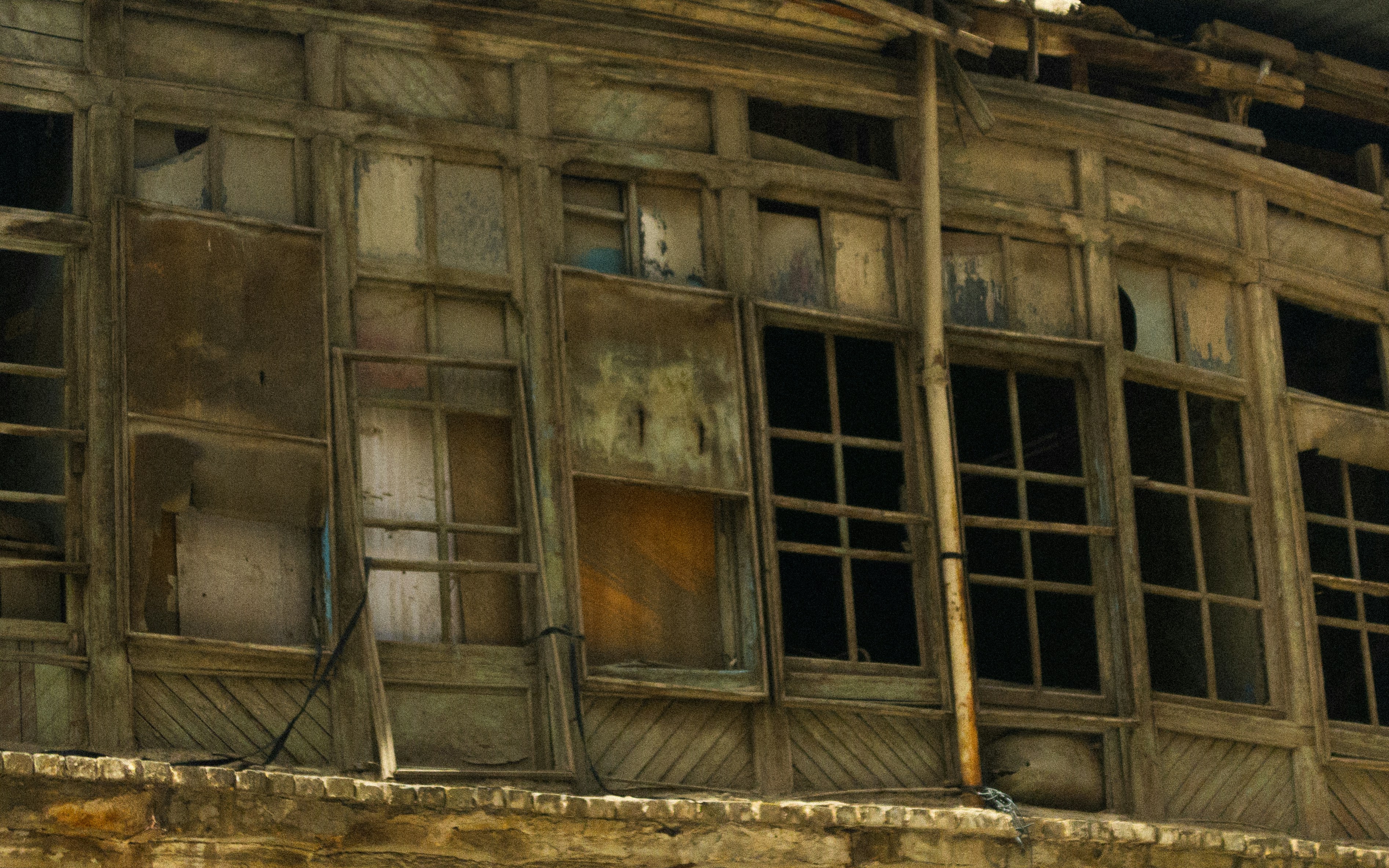 Weathered Facade: Windows as Silent Witnesses to a Deteriorating House