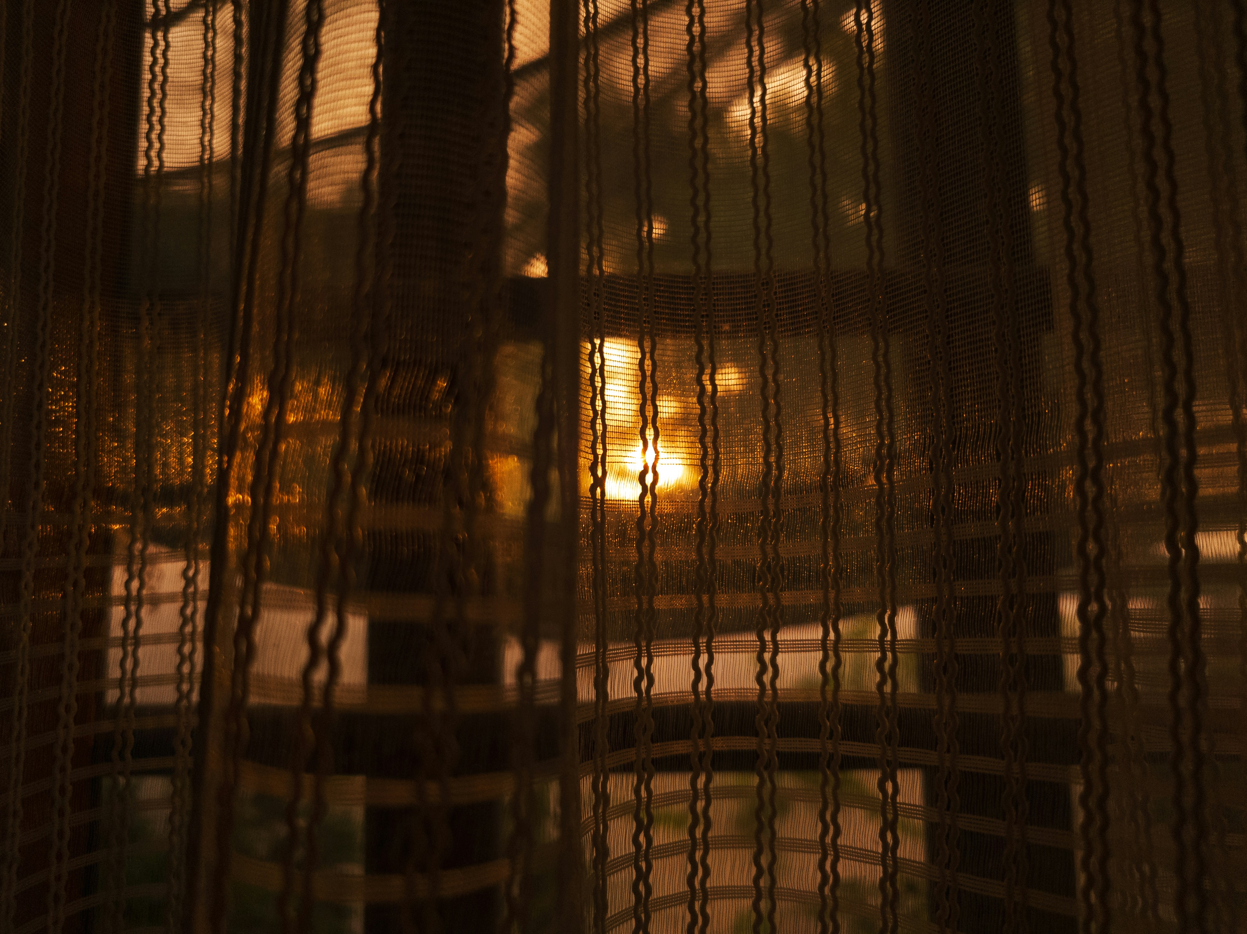 Sunset Through Curtain Chains at Dusk