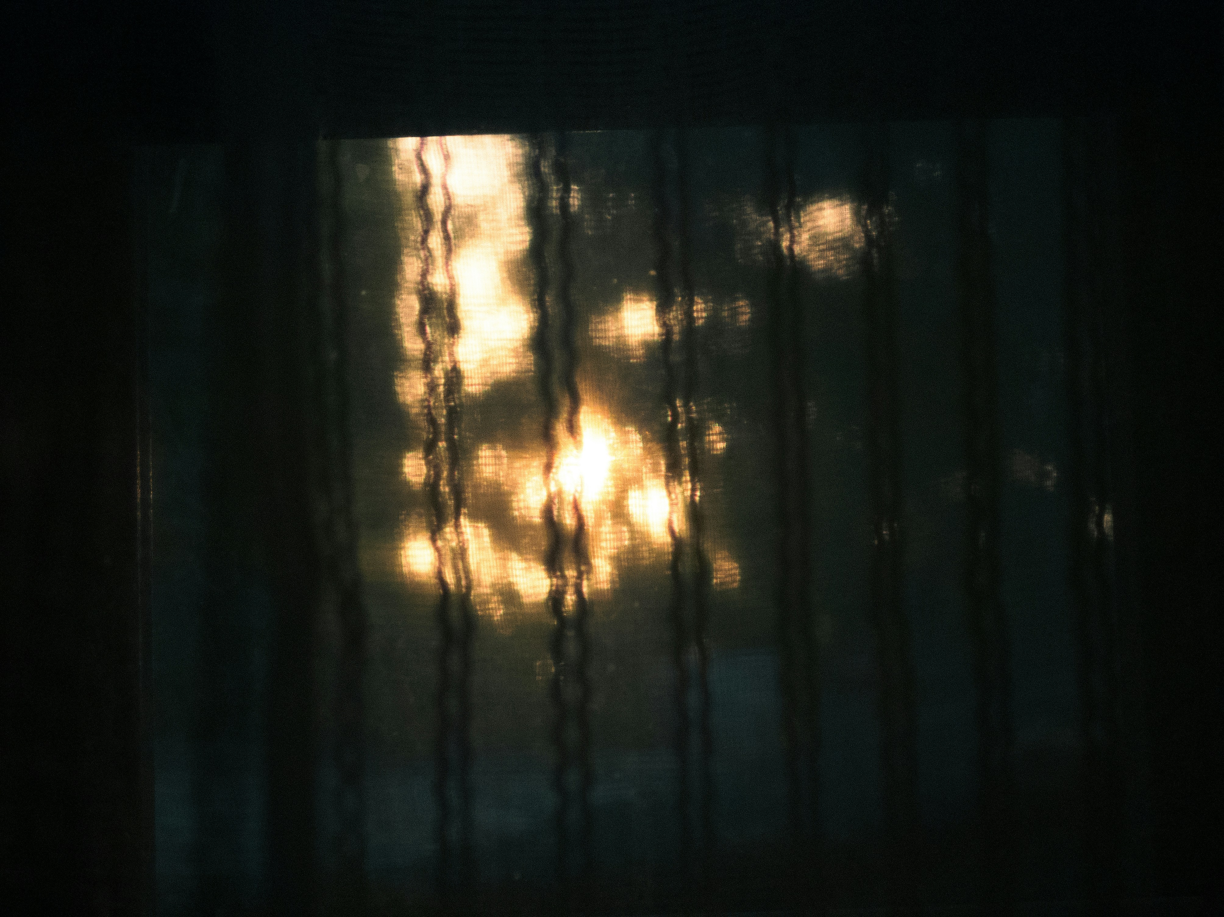 Veiled Sunset Behind Sheer Curtains