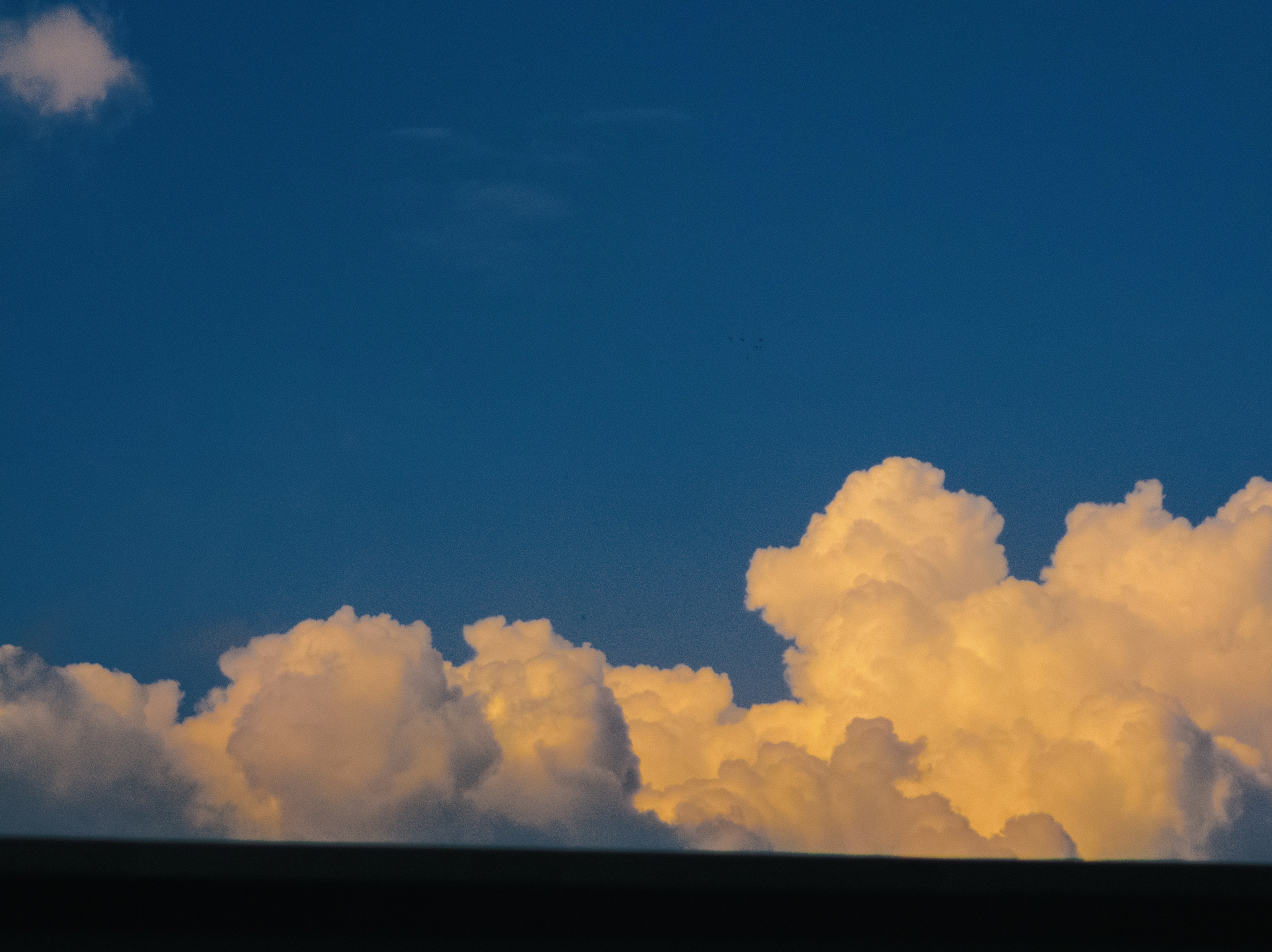 Sunlit Cloudscape Above a Quiet Horizon