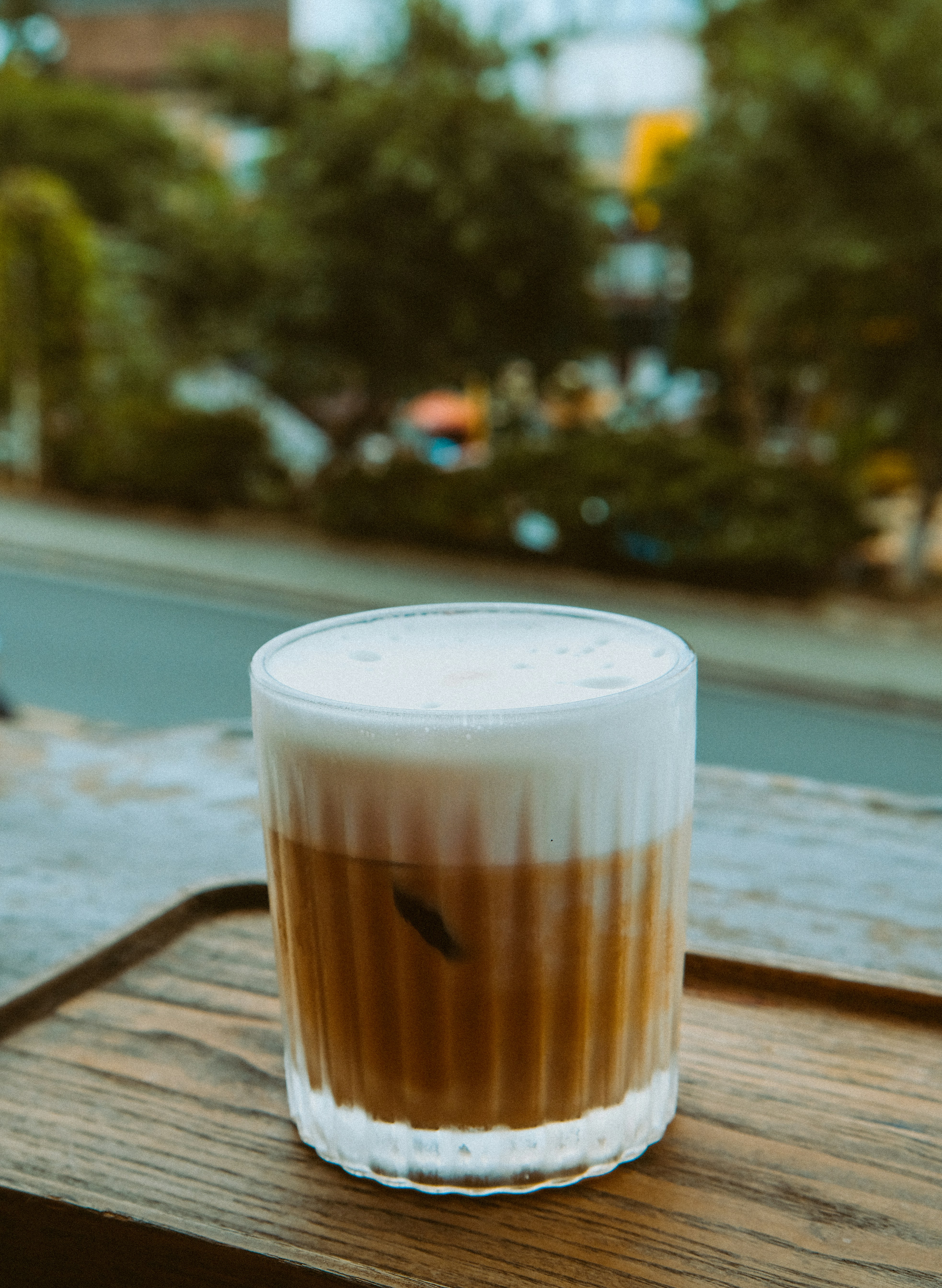 Foamy Dawn: A Glass of Latte on a City Evening Stage