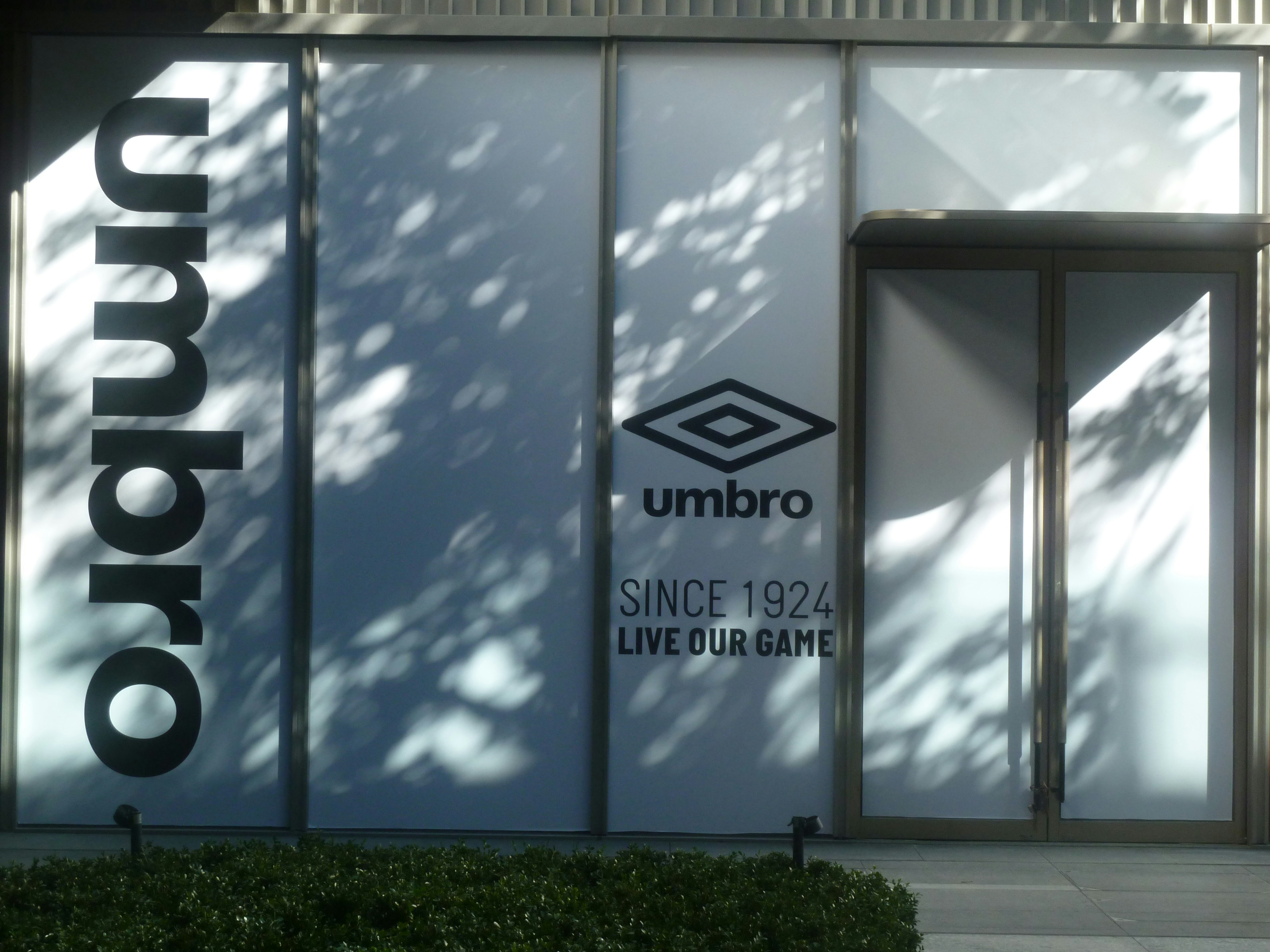 Umbro Wall — Brand Signage on a Shadowed Building Facade
