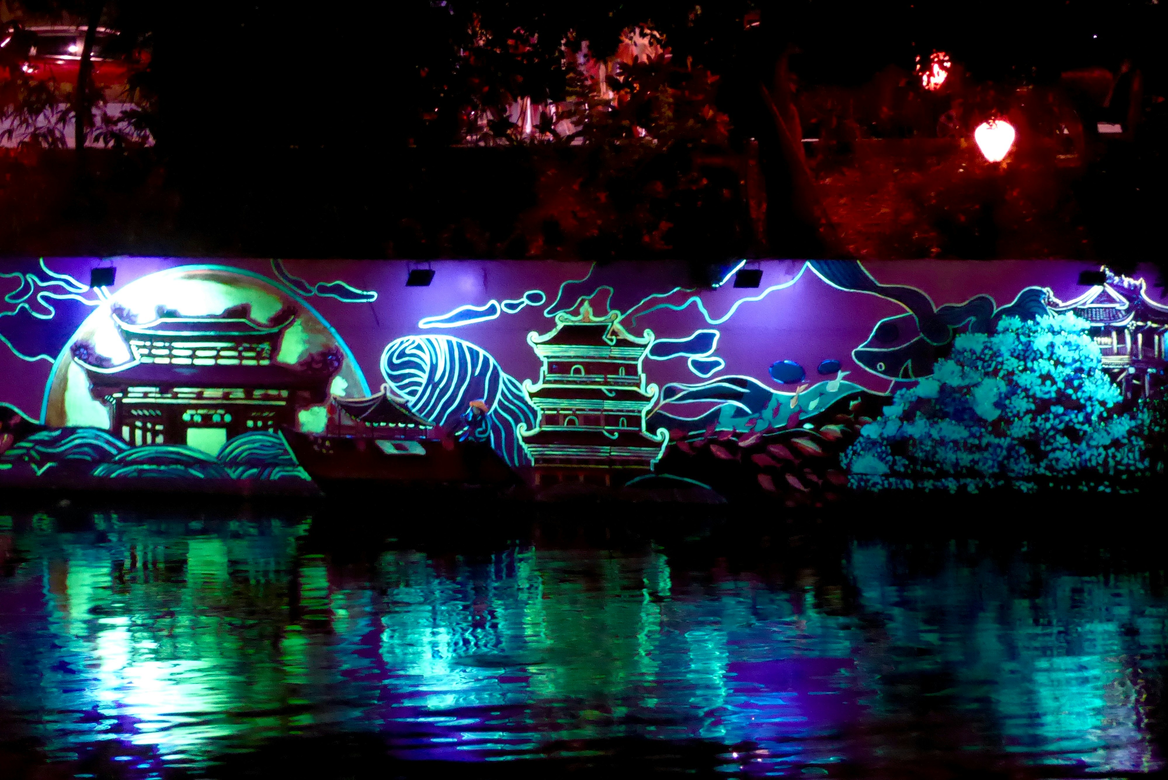 Neon mural by the water: lit pagoda and zebra silhouette under midnight glow