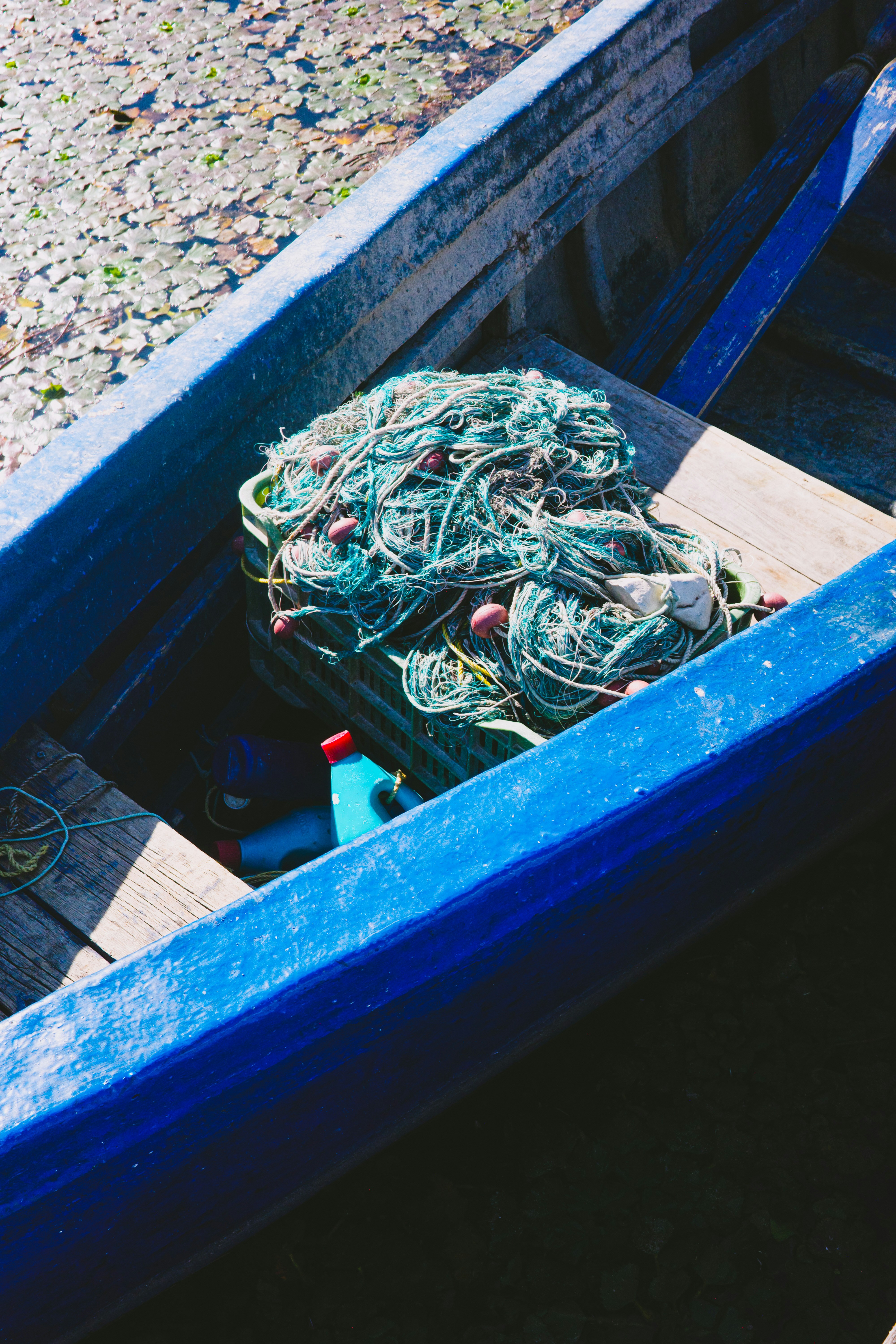 Coiled nets and buoyant blue: a fisherman's boat stash