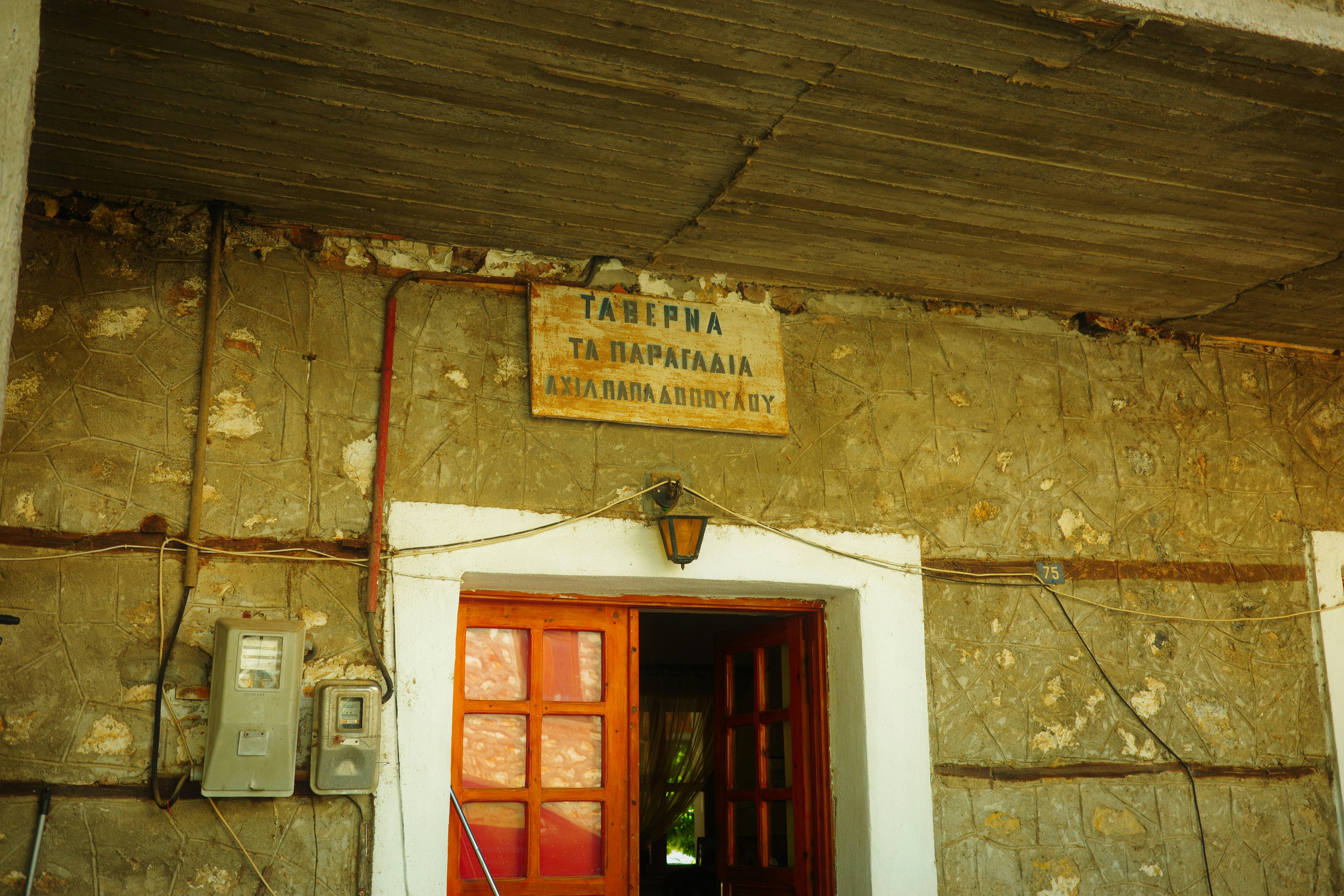 Weathered doorway of a rustic tavern beneath a concrete ceiling